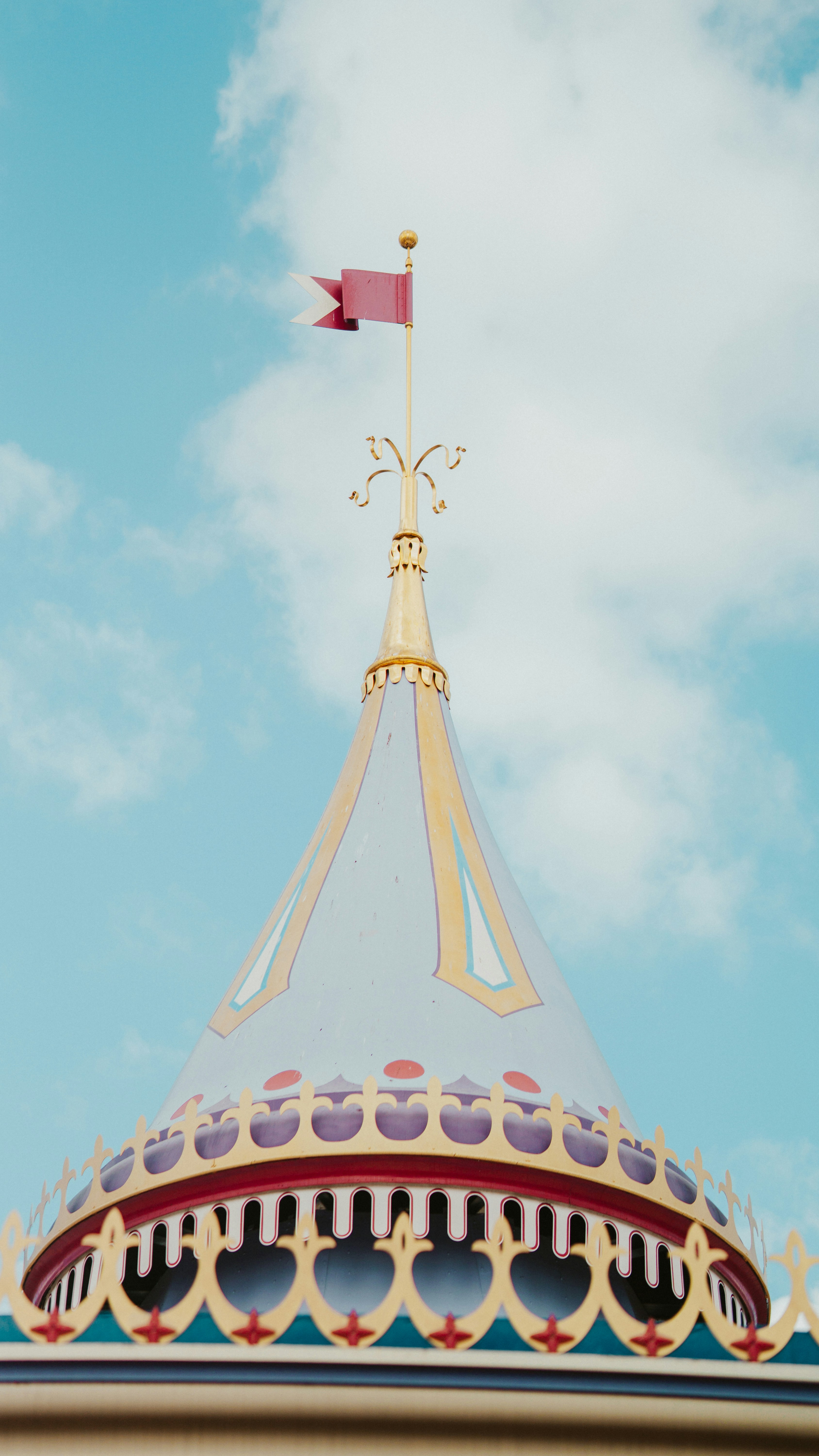 Opal Spire: Gold Trim and Pink Banner Crown a Pastel Rooftop