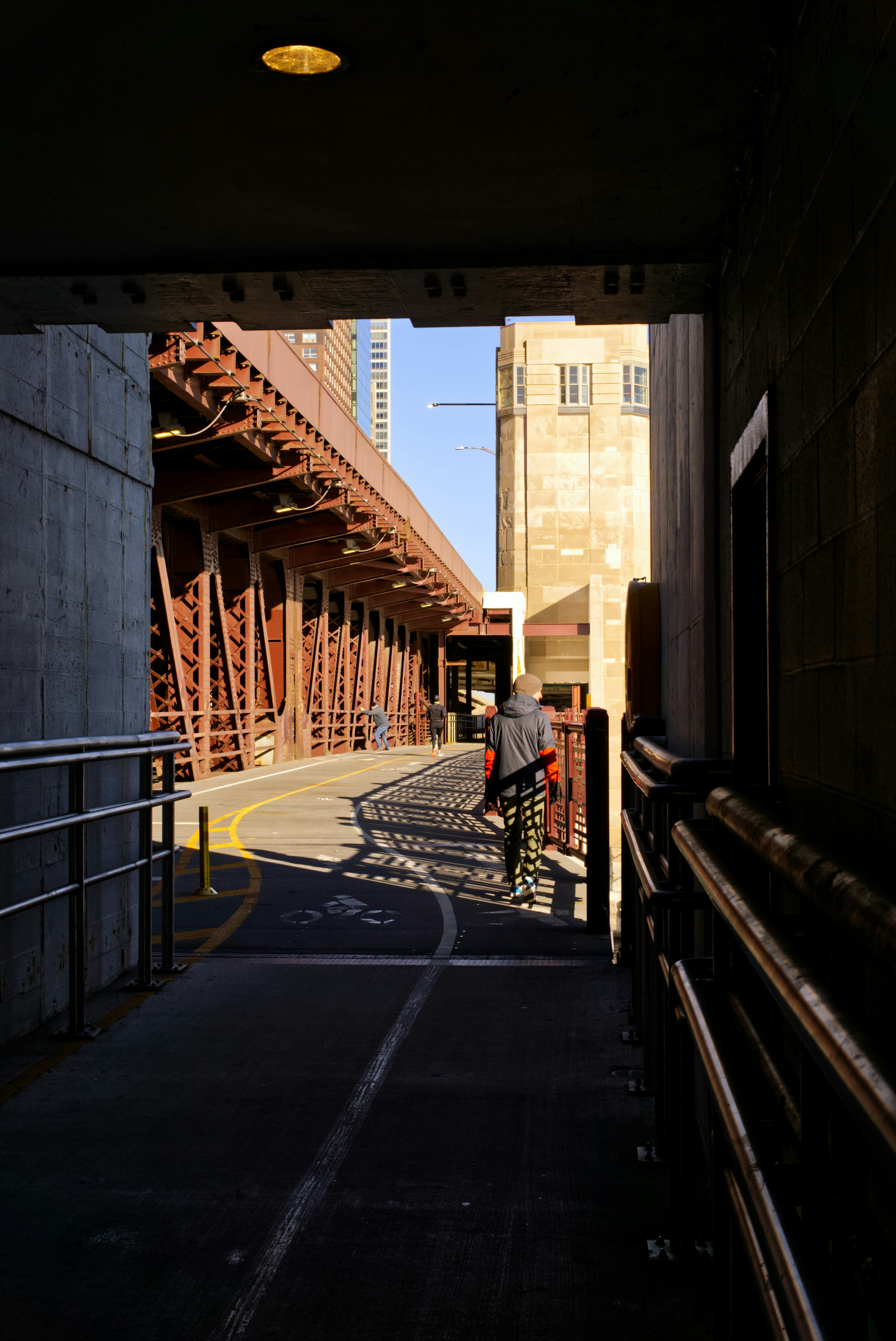 Walkway of Steel: A Lone Figure Emerges Toward Daylight