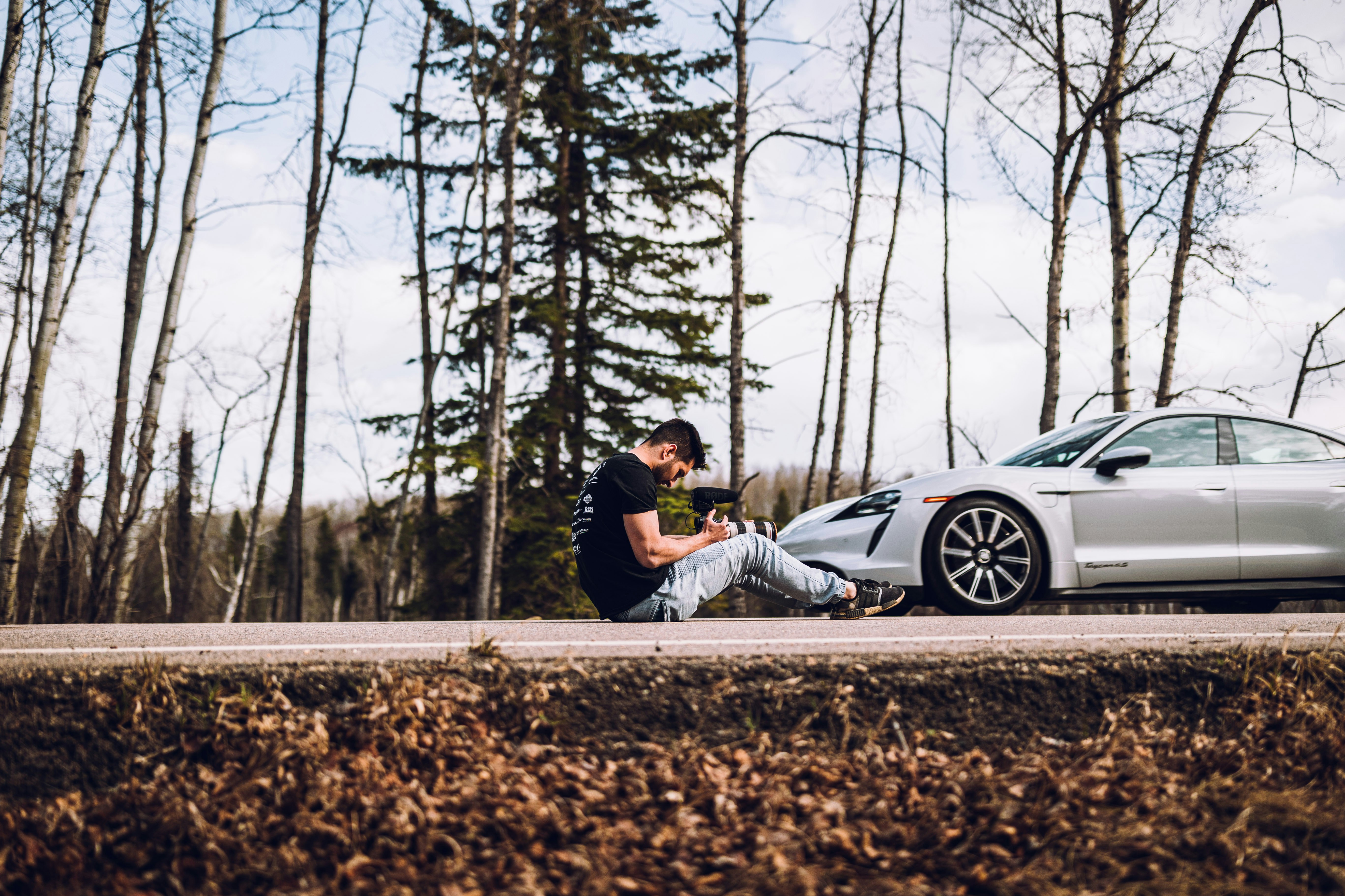 A man sitting on the curb next to a car photo – Free Sitting Image on ...