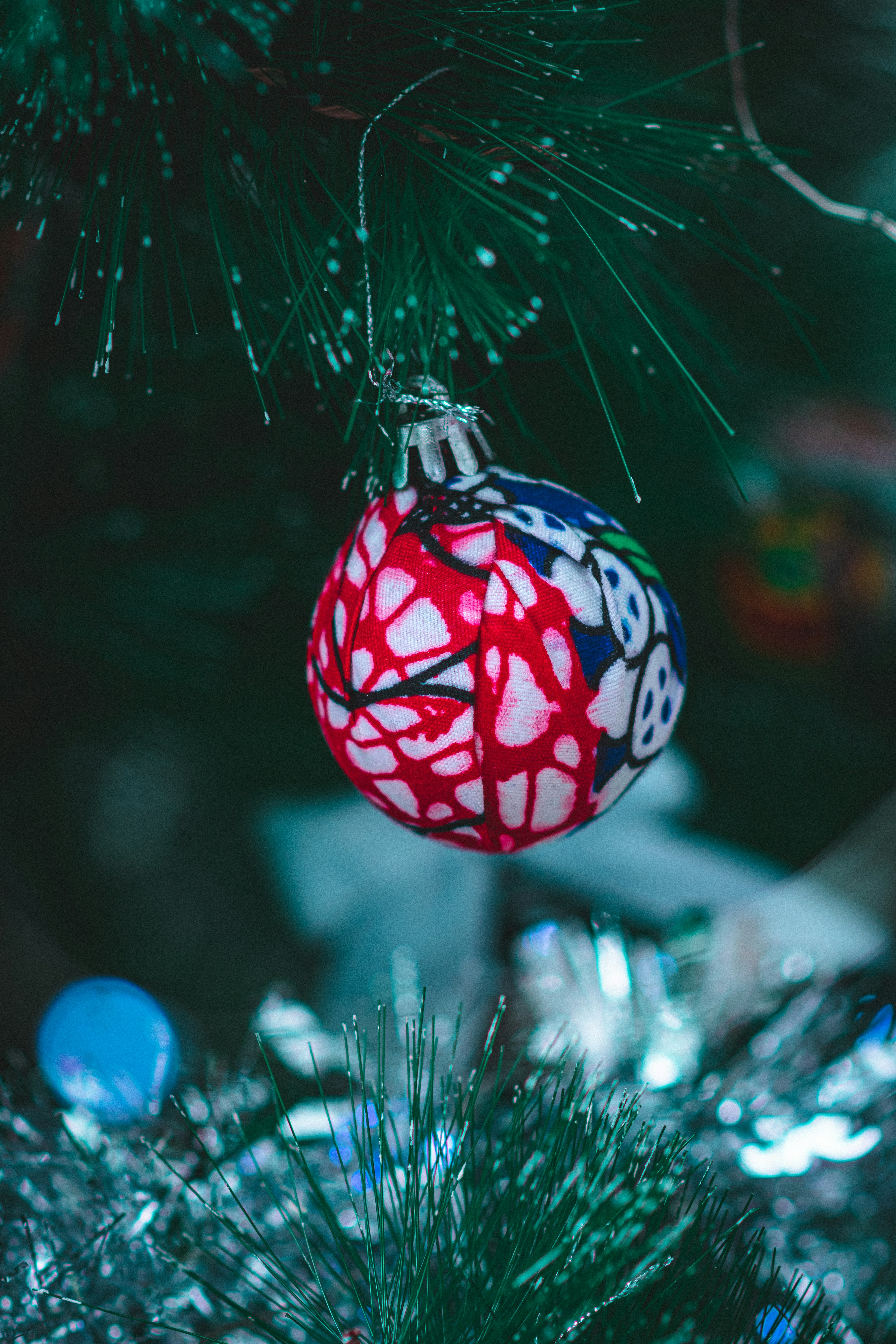 Crimson Mosaic Ornament Hanging Amid Dew-Kissed Pine Needles