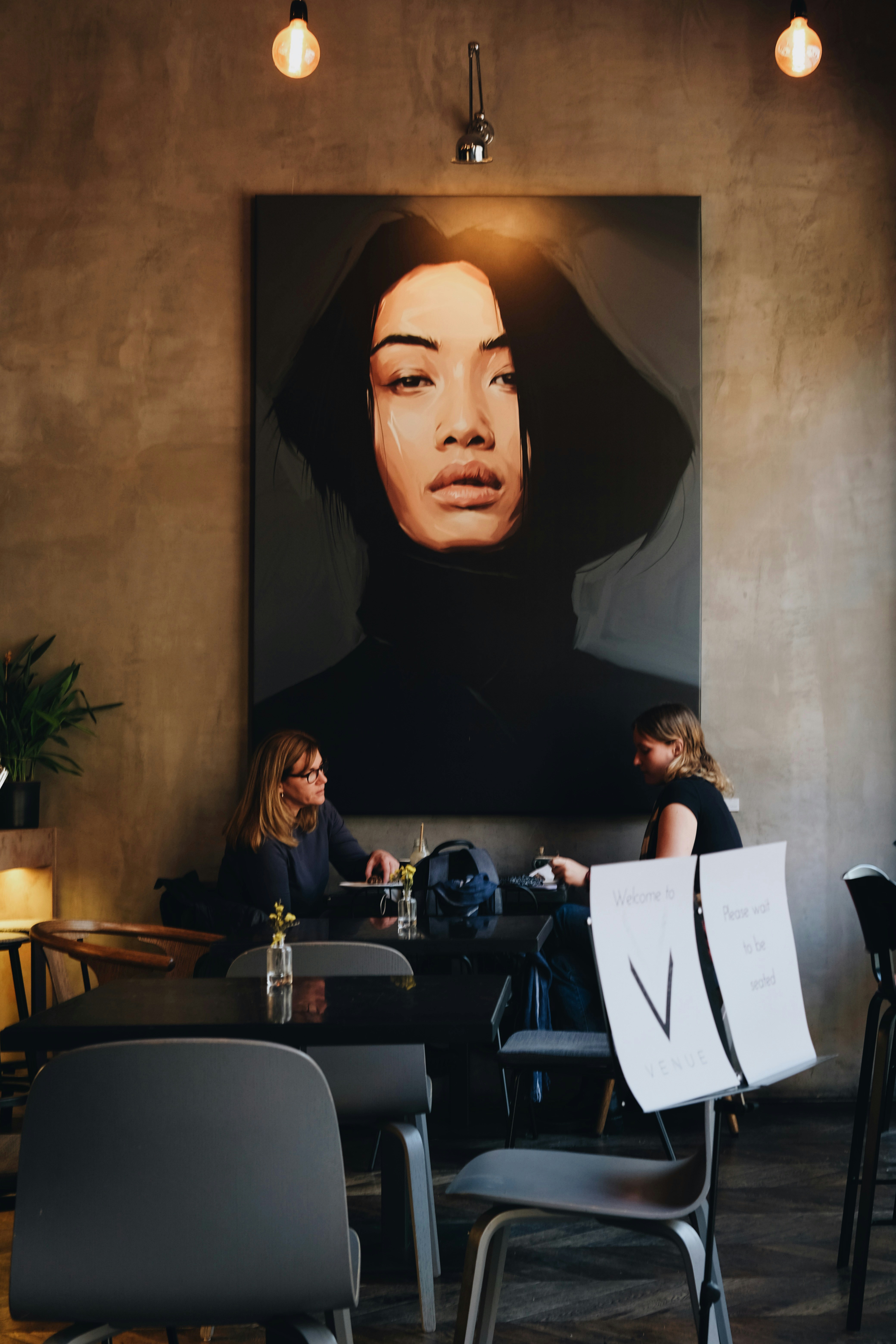 Portrait in a Dim Loft: A Bold Canvas Above the Table