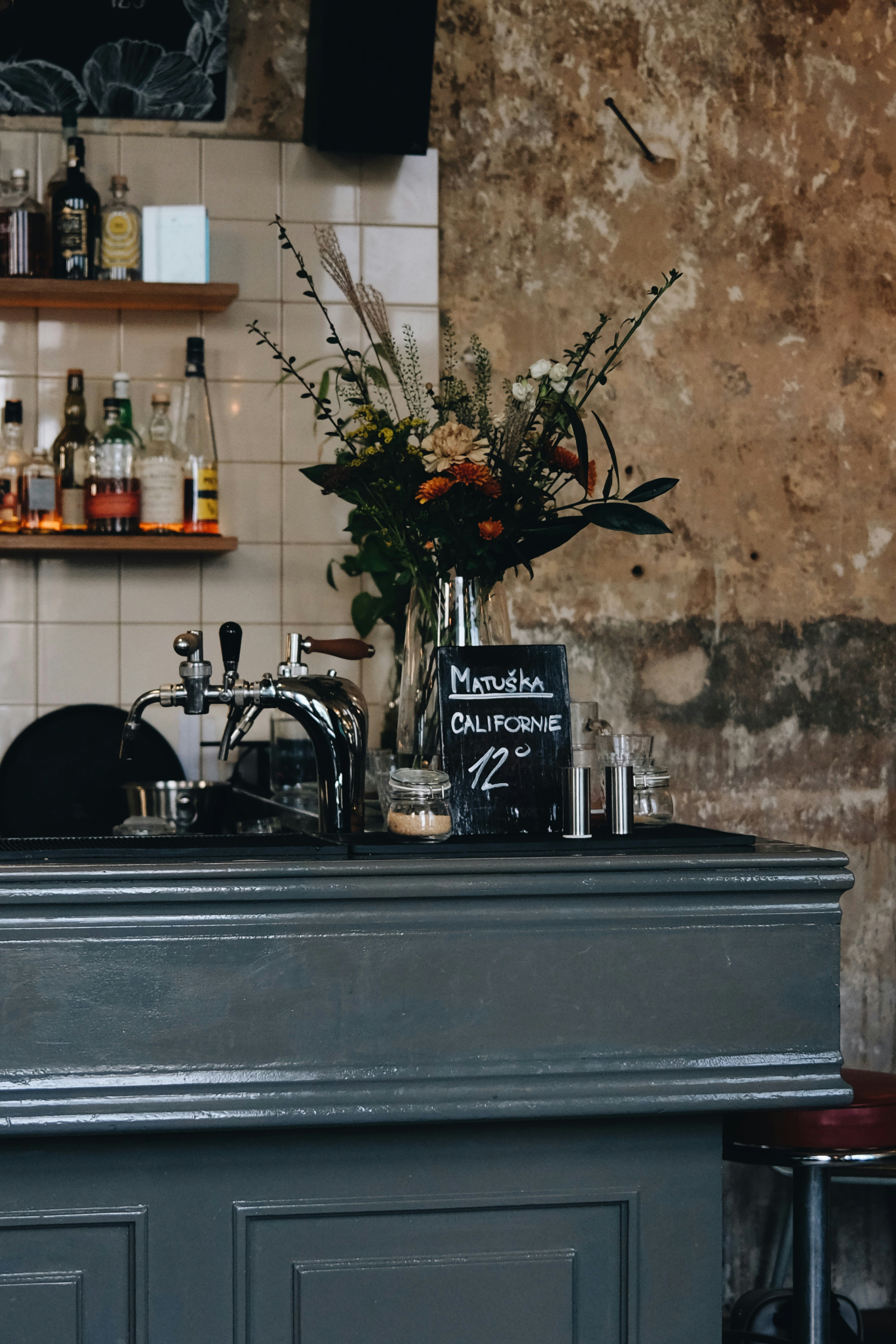 Flower Vase at a Rustic Bar Counter with Chalkboard Sign