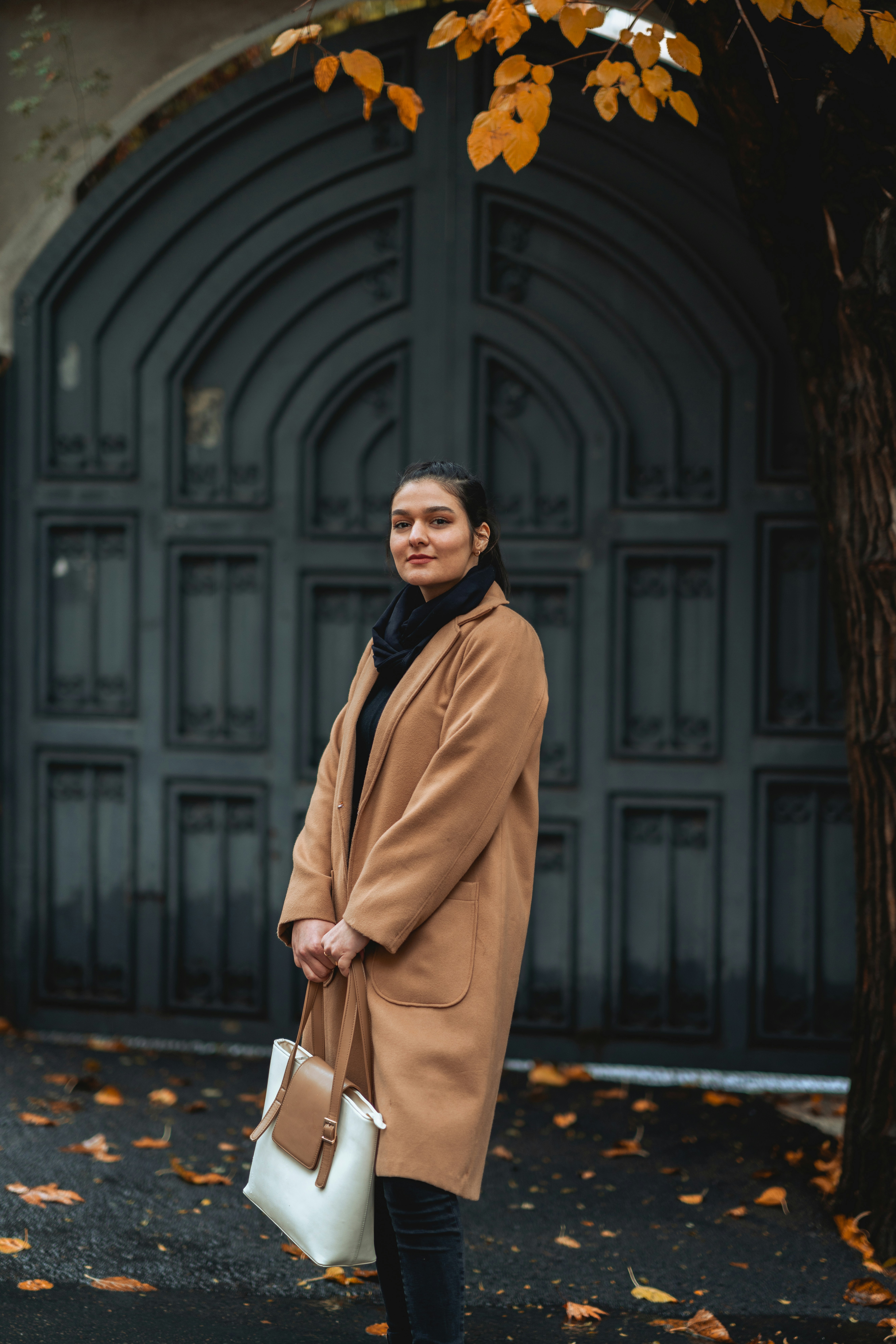 A person standing outside a building photo – Free Coat Image on Unsplash