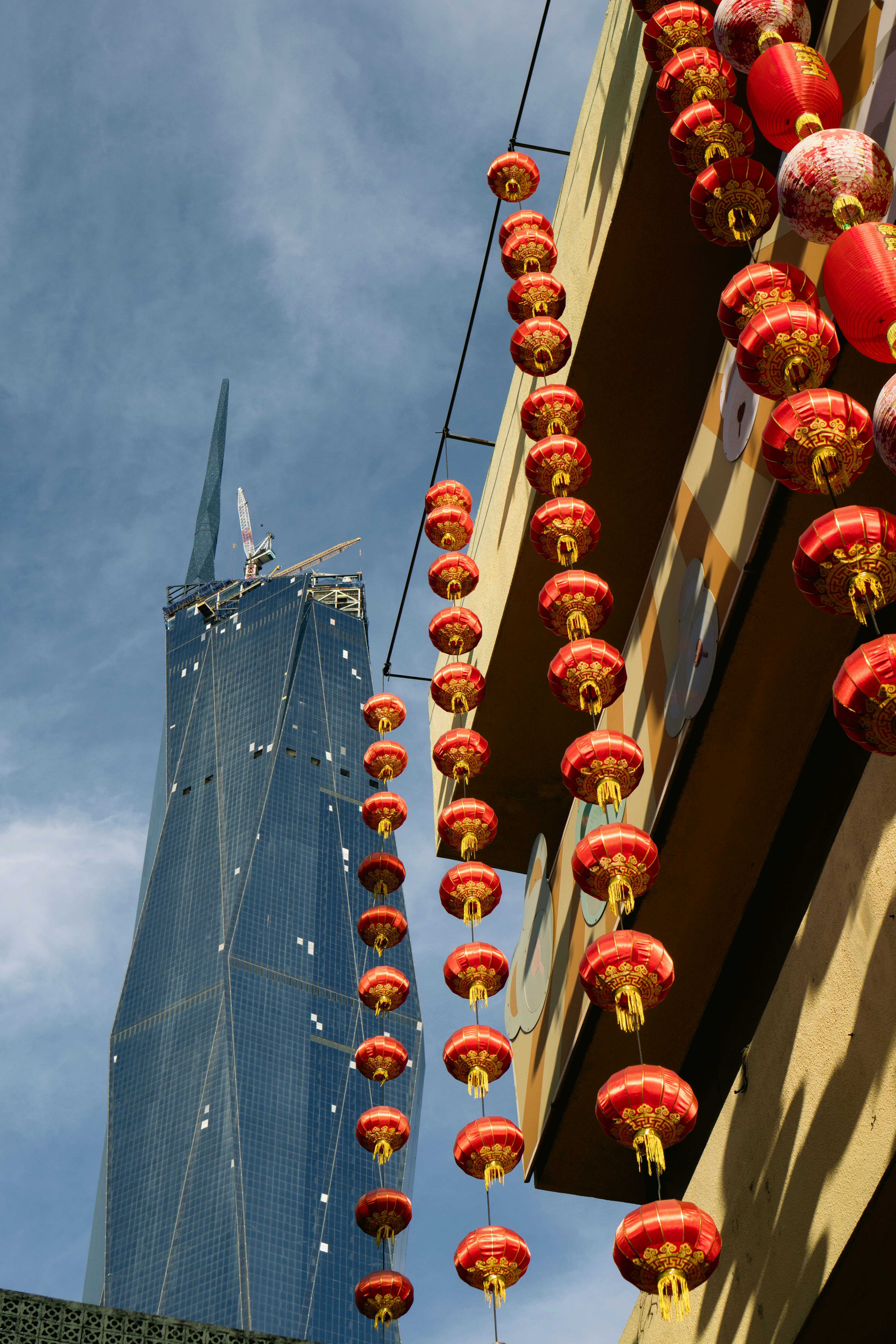 Lantern Garland Framing a Skyscraper Against a Crisp Blue Sky