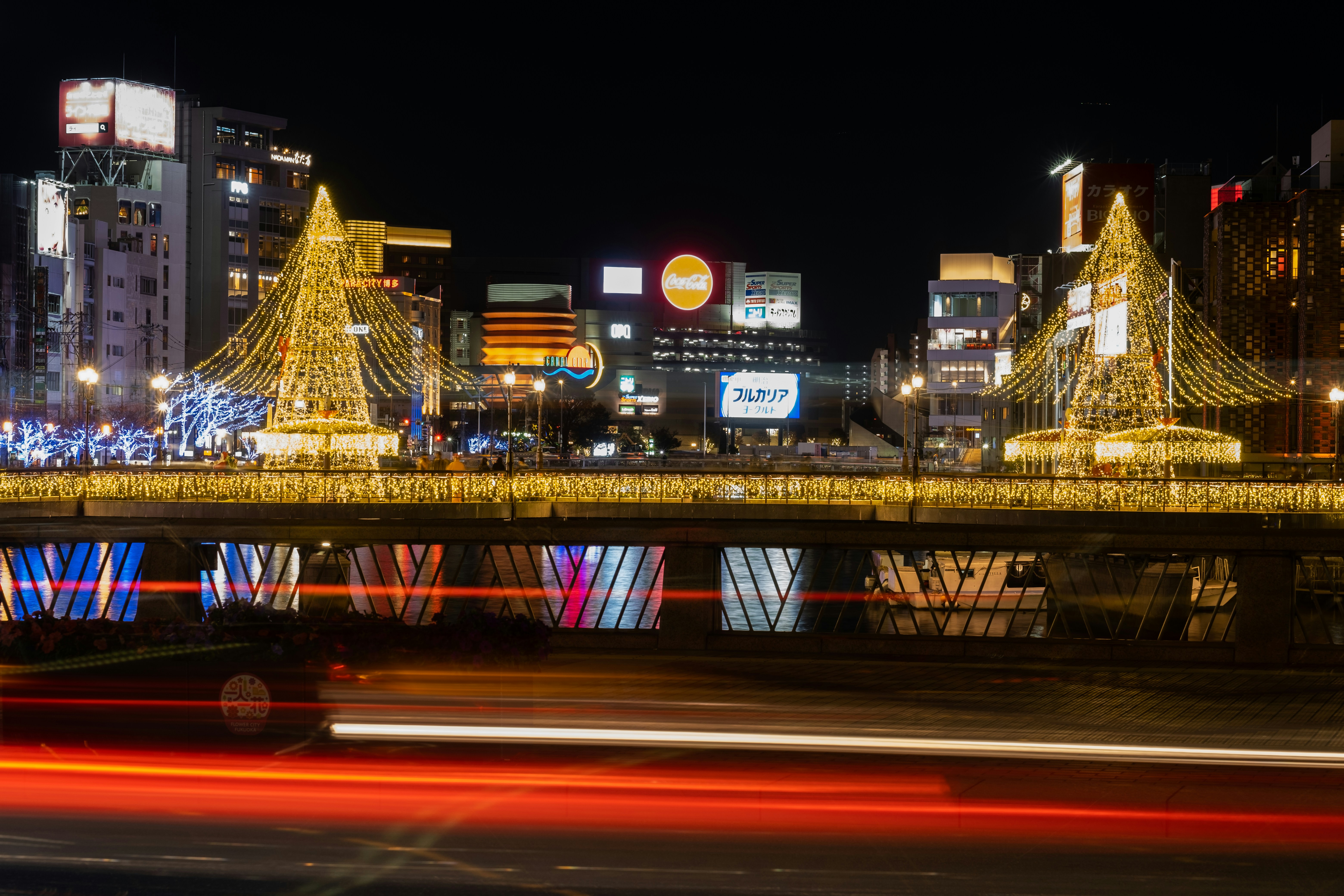 Threaded Neon on a Night Bridge: Lights, Trees, and Moving Traffic