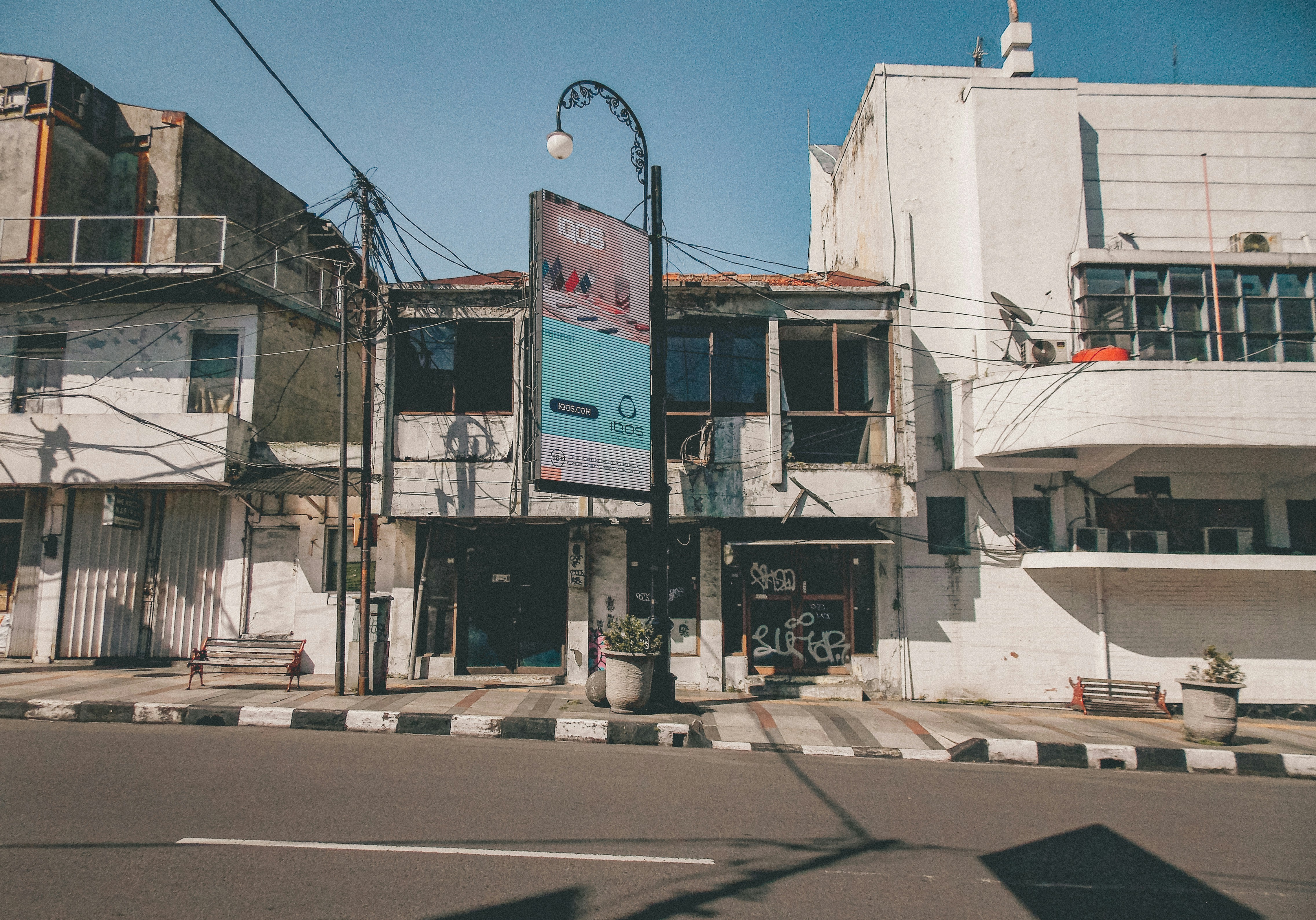 Central Signpost Framed by Weathered Storefronts on a Sunlit Street