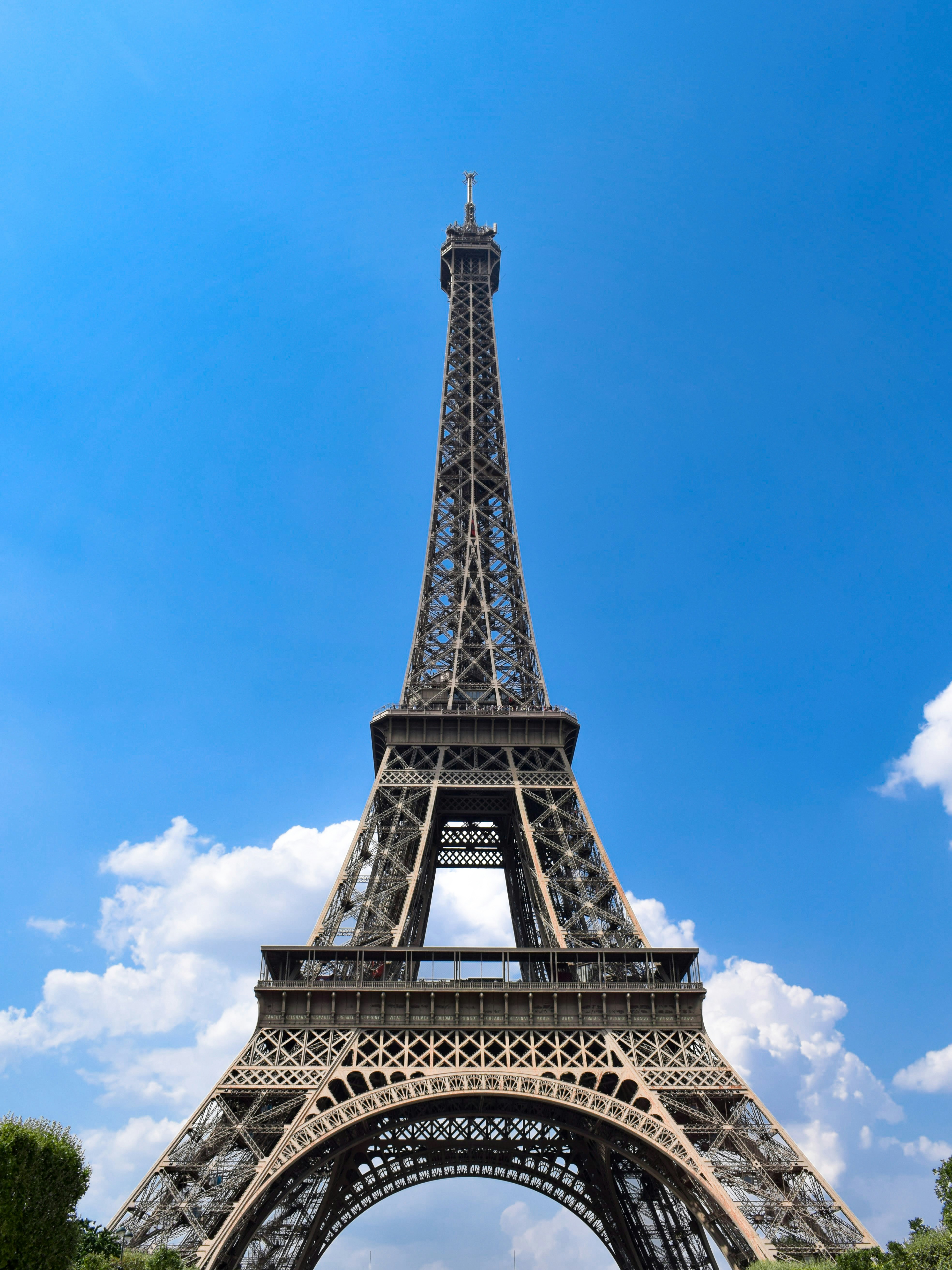 Foto Una alta torre de metal con la Torre Eiffel al fondo – Imagen ...