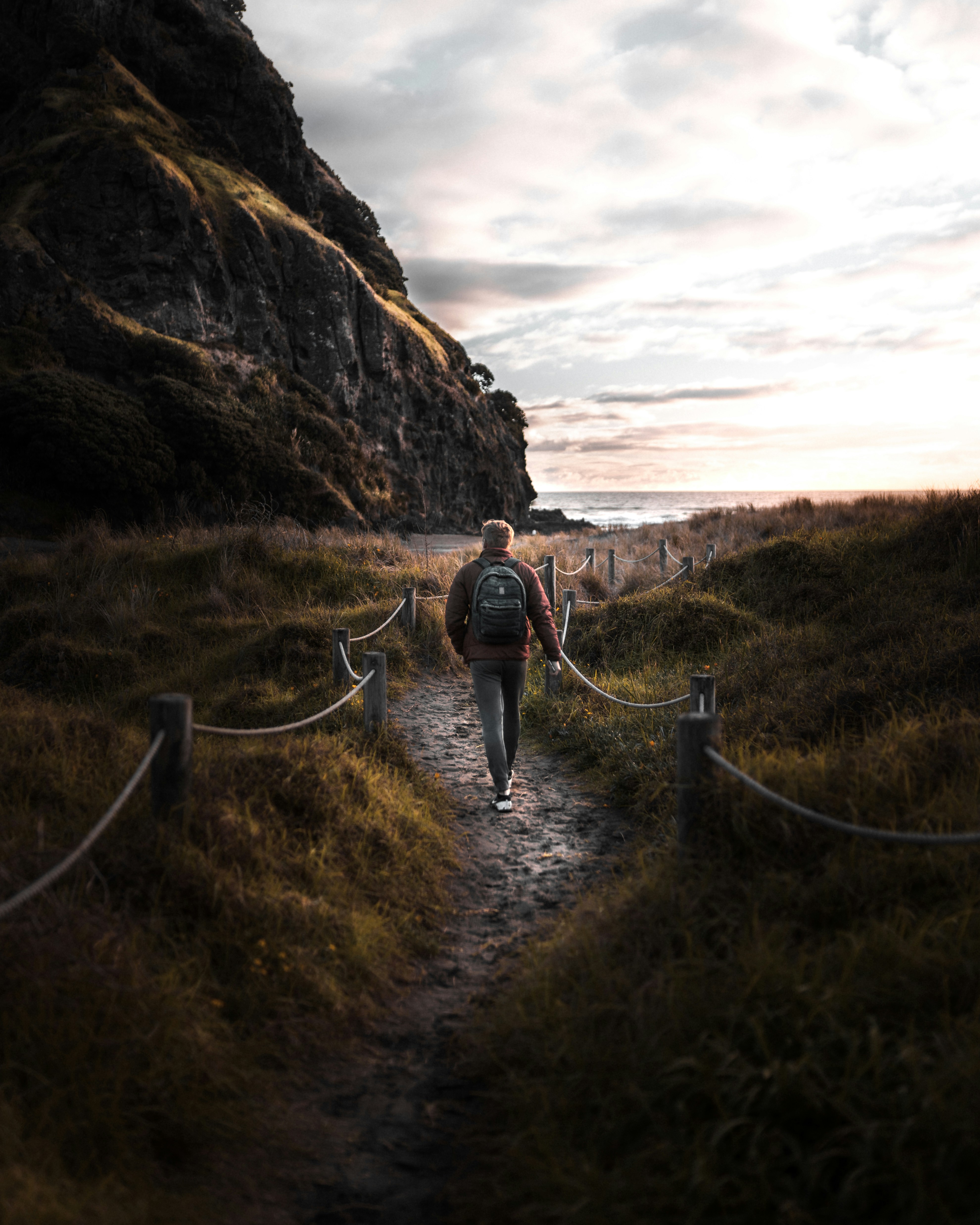 A person walking on a path between cliffs photo – Free Guy Image on ...