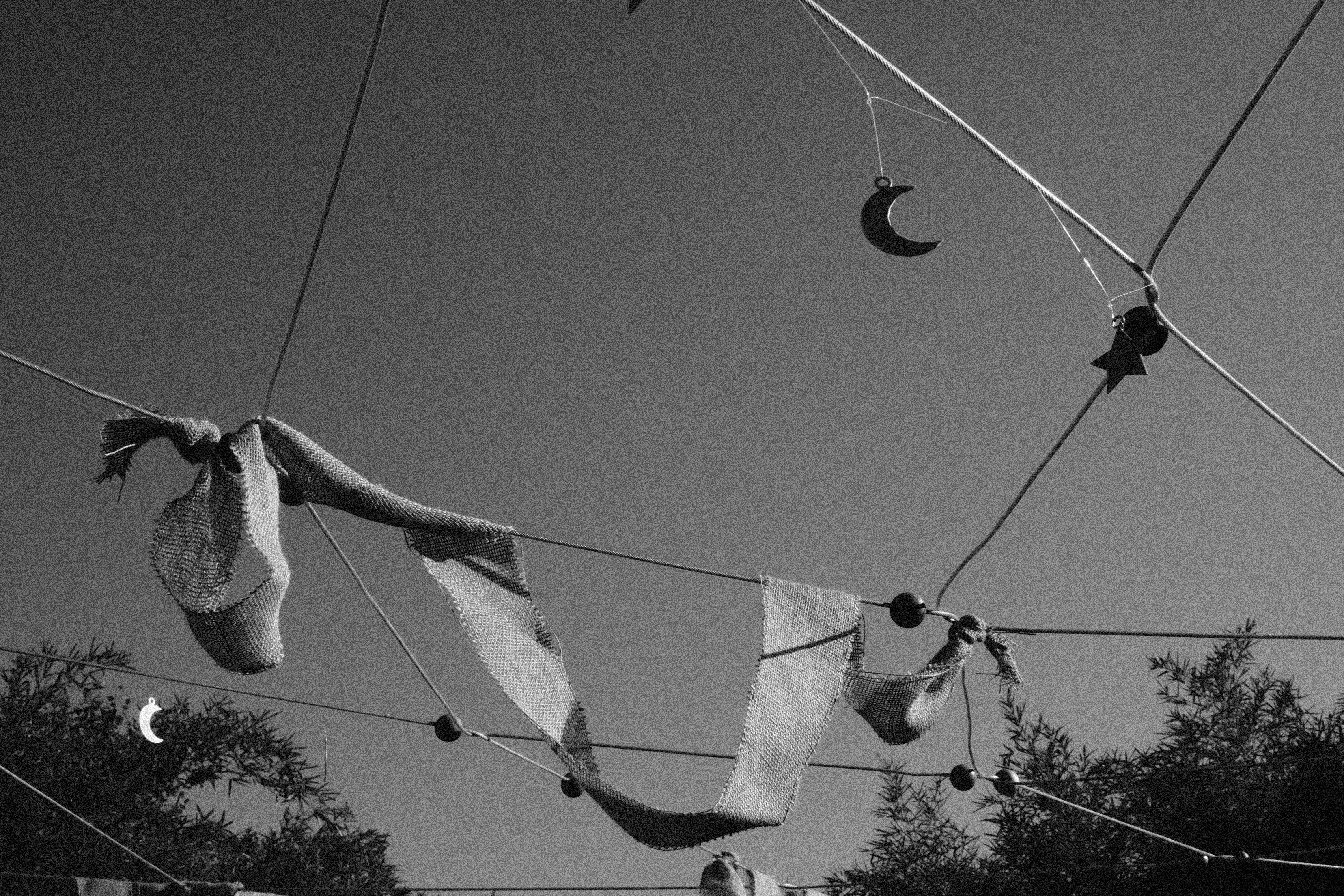 Tattered prayer flags drifting over sunlit wires