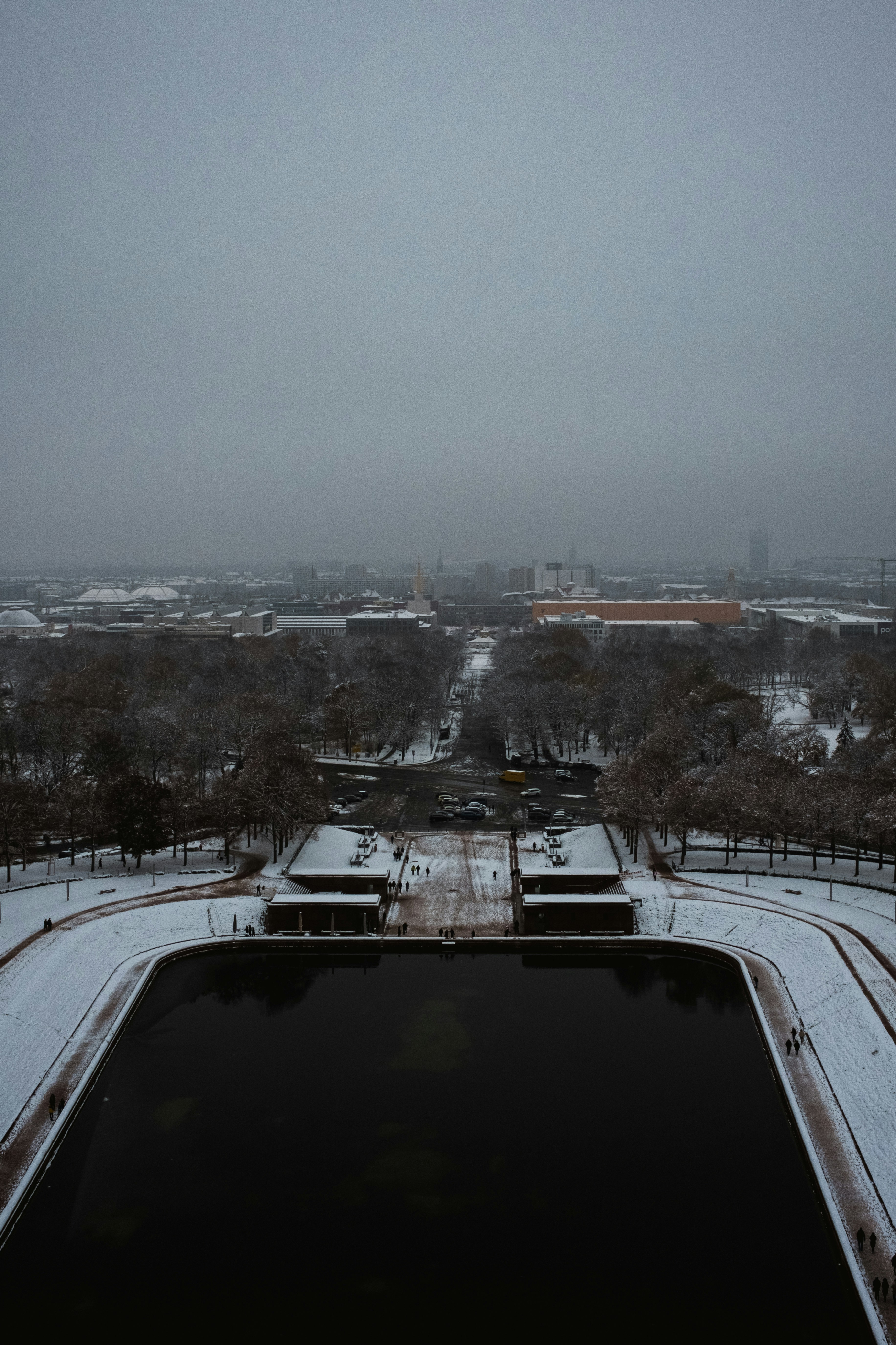 Snowbound Axis: A Reflective Pool Framing a Distant City Horizon