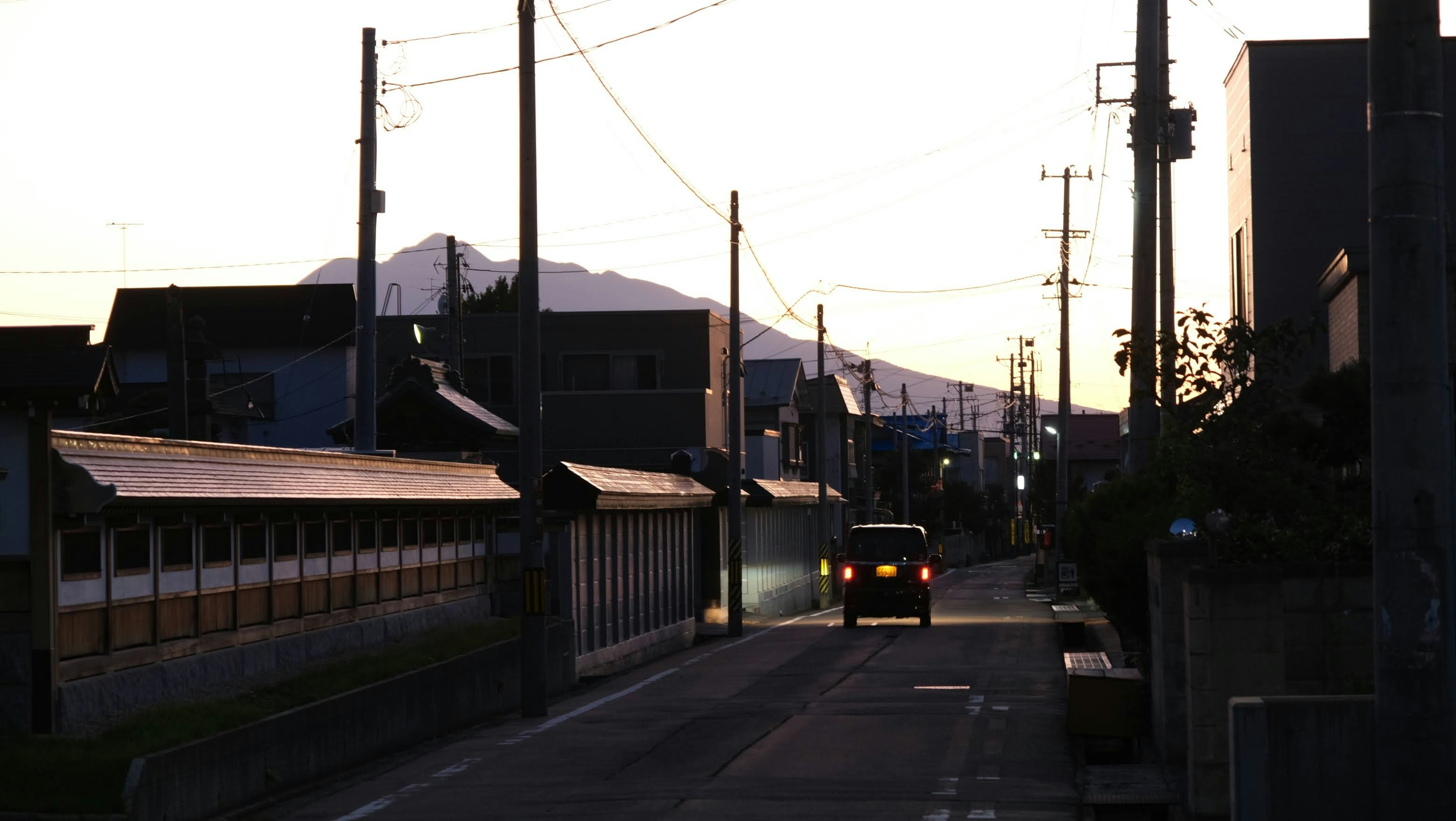 Dusk on a Quiet Suburban Road: A Lone Car Approaches