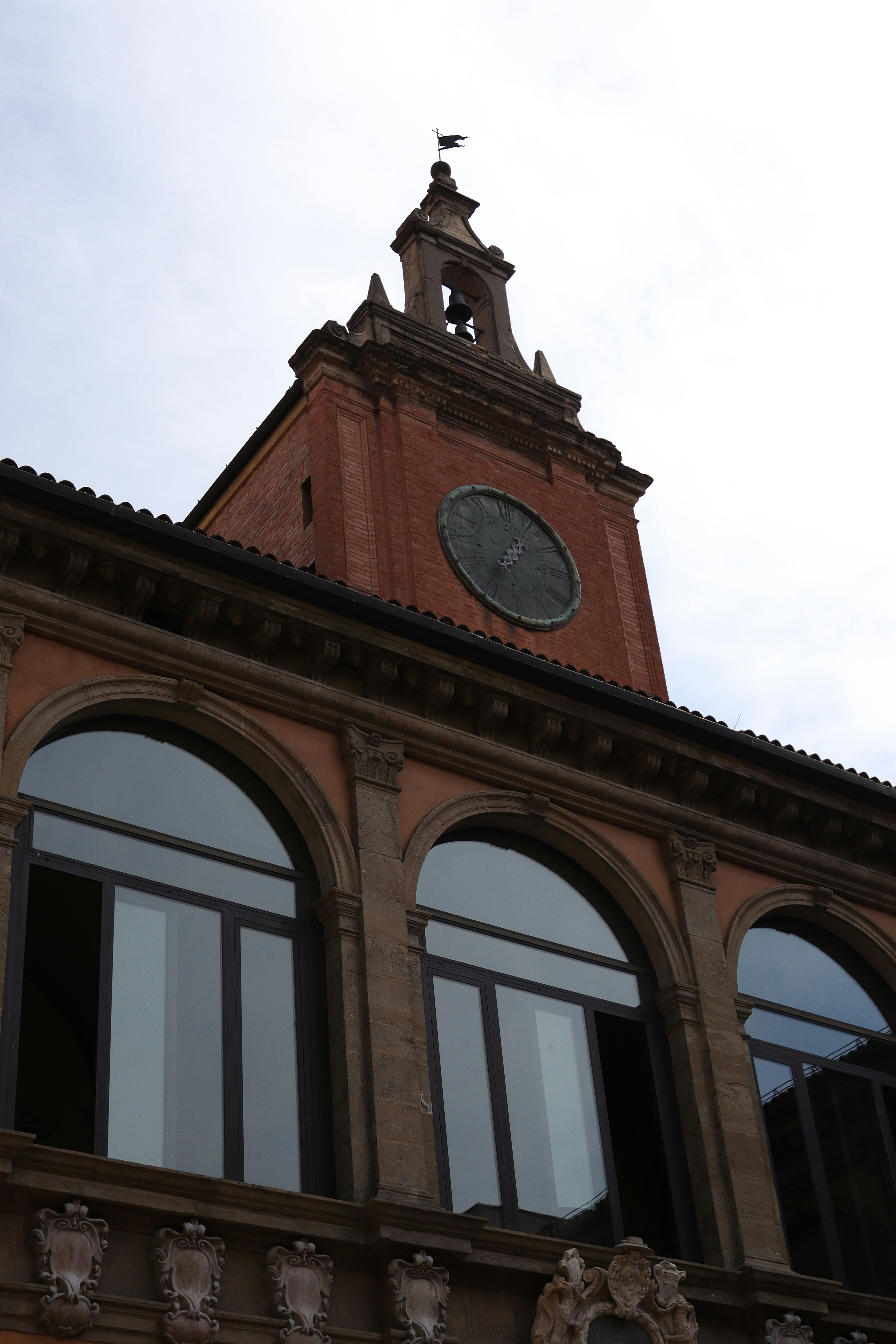 Brick Clock Tower Above Arched Facade: A Quiet Sky