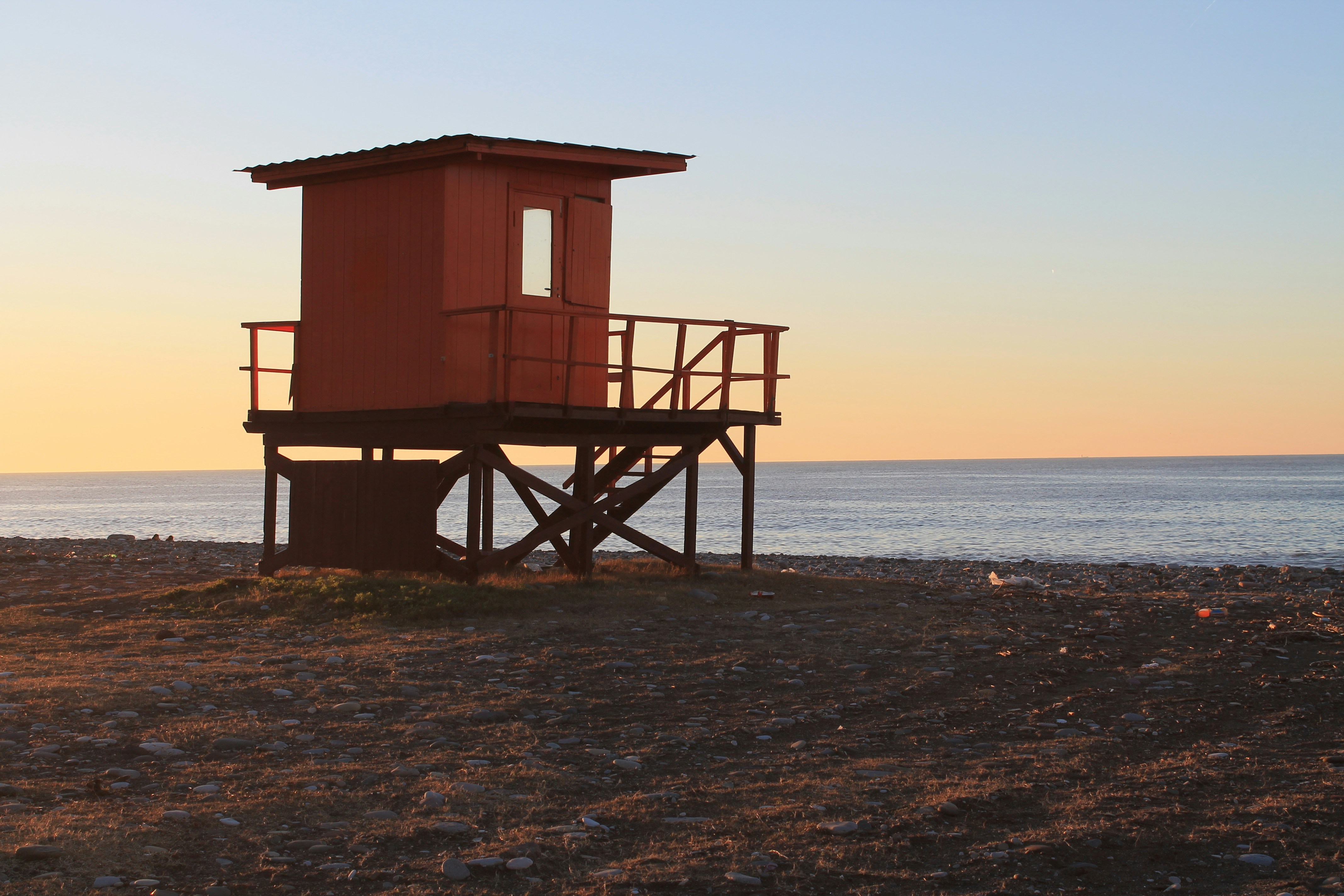 Dusk Over the Red Lifeguard Hut: A Quiet Sentinel by the Sea
