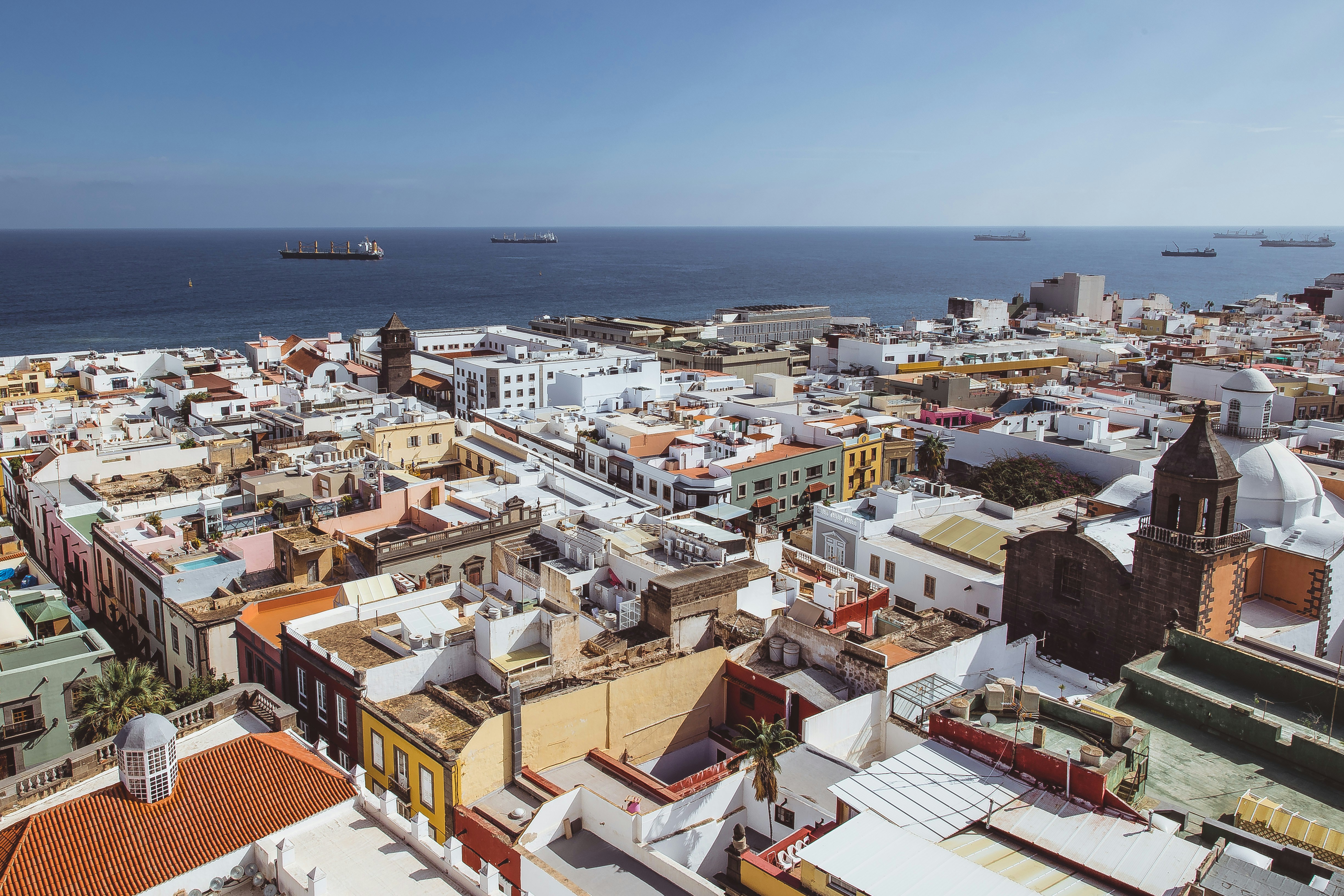 a city with many buildings and a body of water in the background