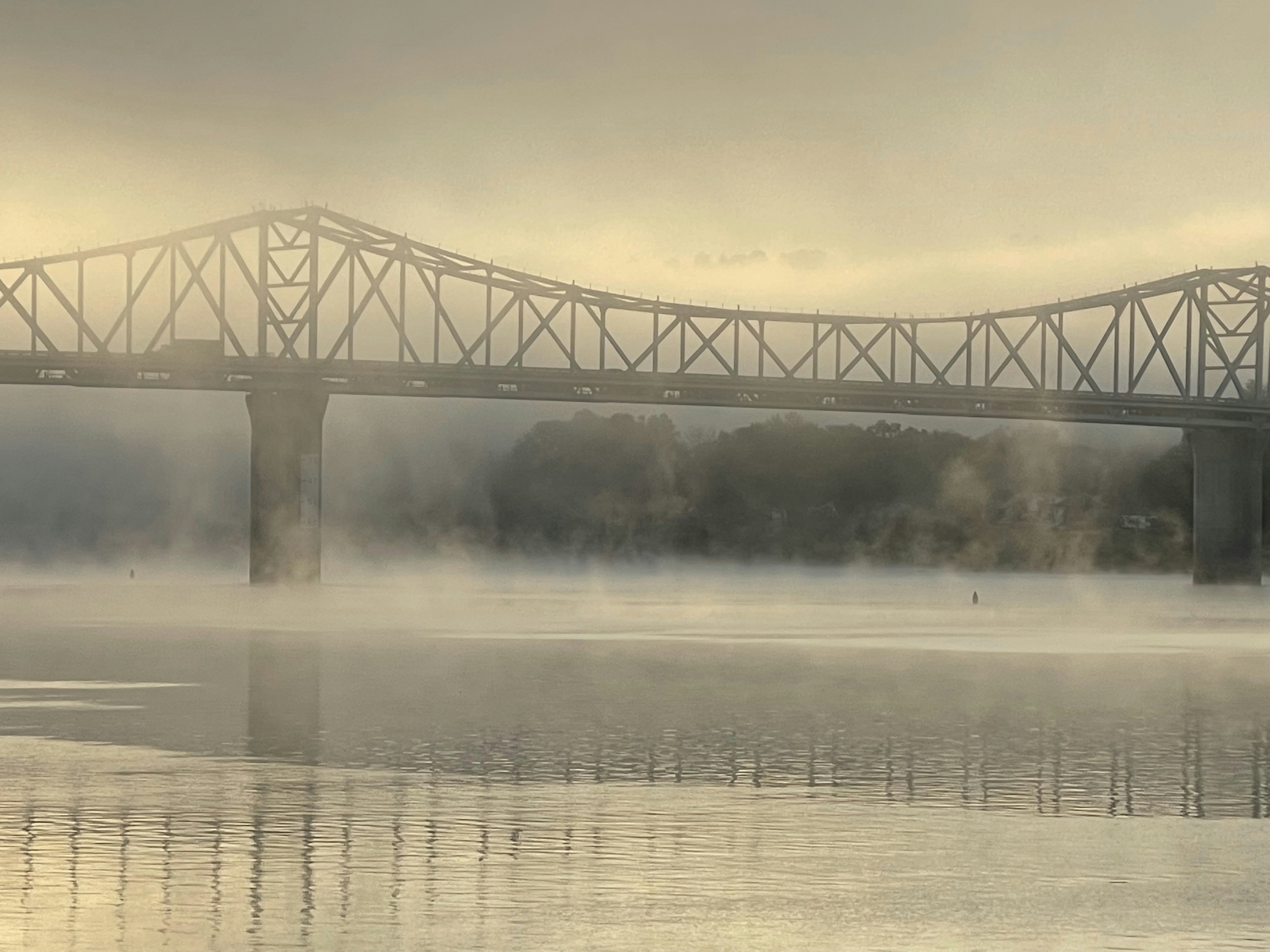 Dawn Shimmer Over the River: Fog-Draped Truss Bridge