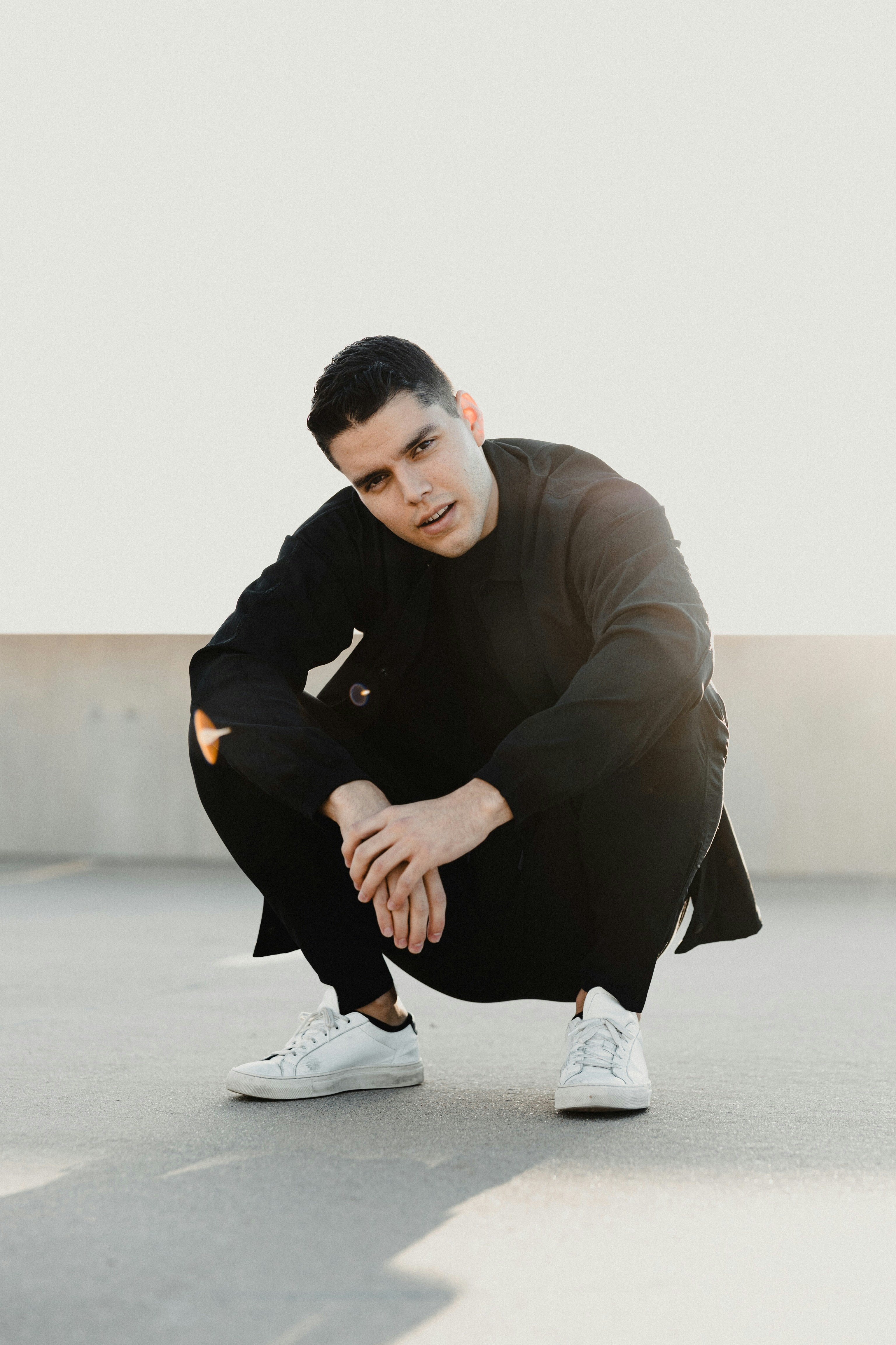 A man squatting down and posing for the camera photo – Free Person ...