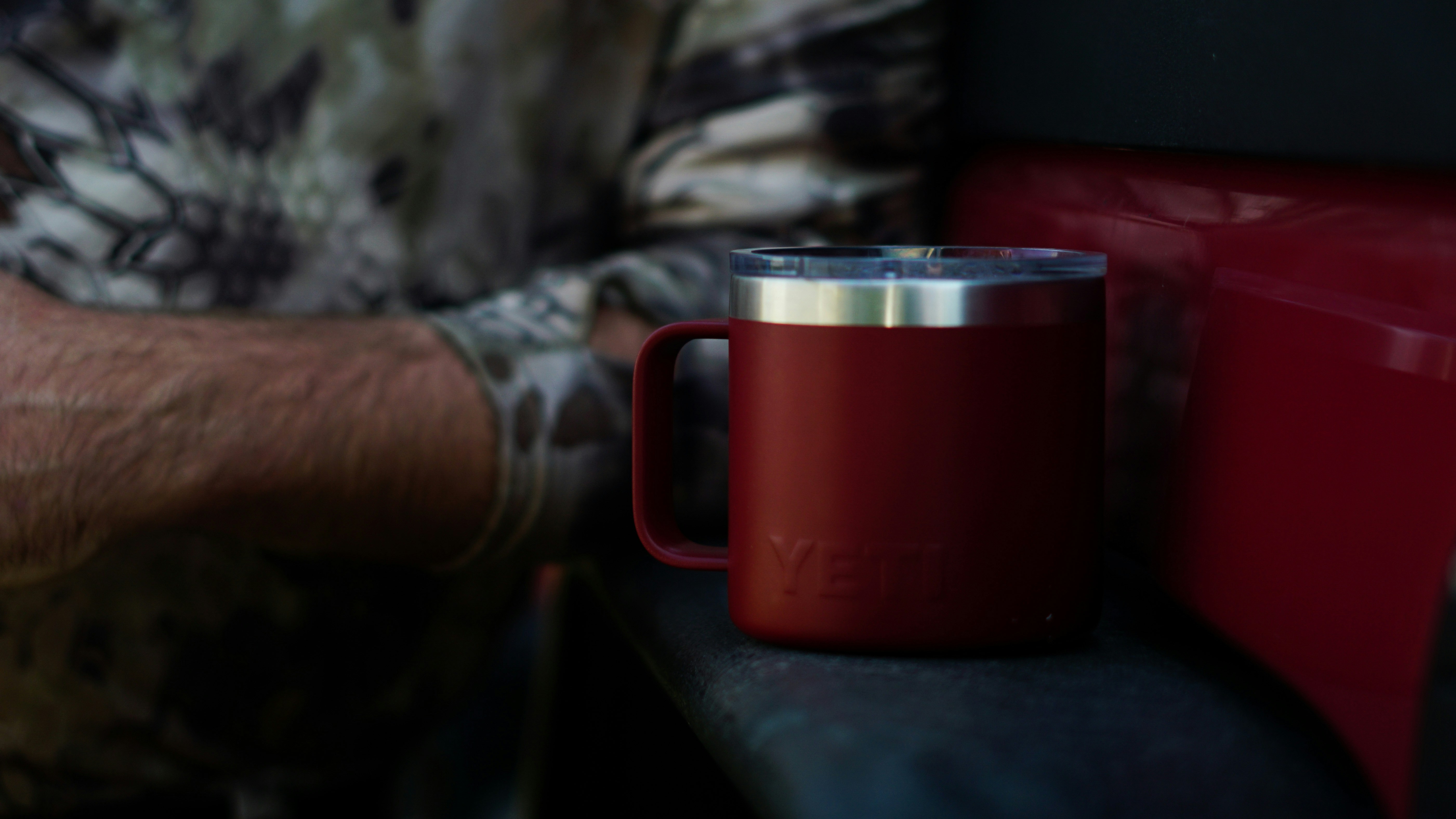 A man holding a red coffee mug on a bench photo – Free Cup Image on ...