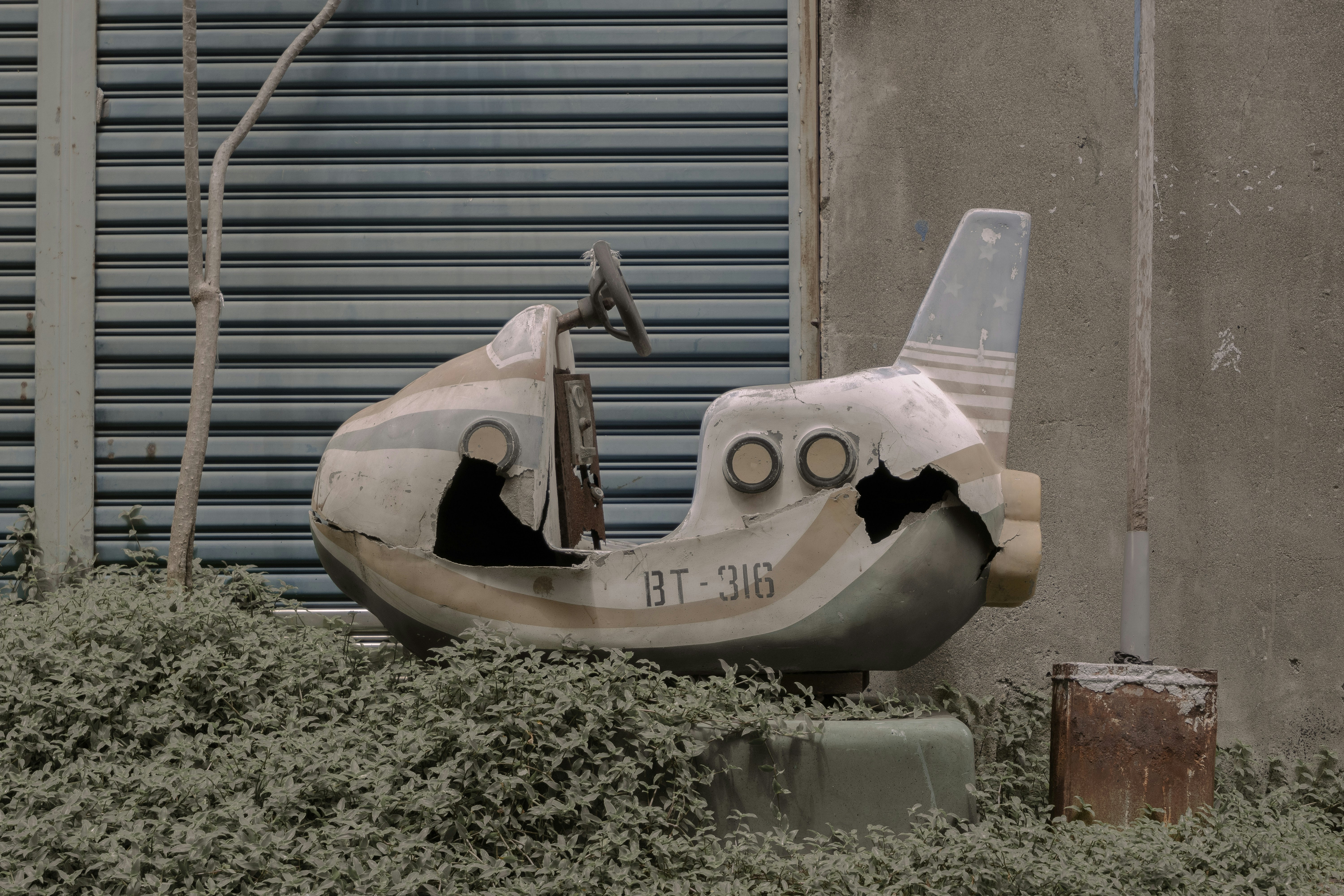 Cracked Cocoon: The Weathered Microjet in an Overgrown Industrial Yard