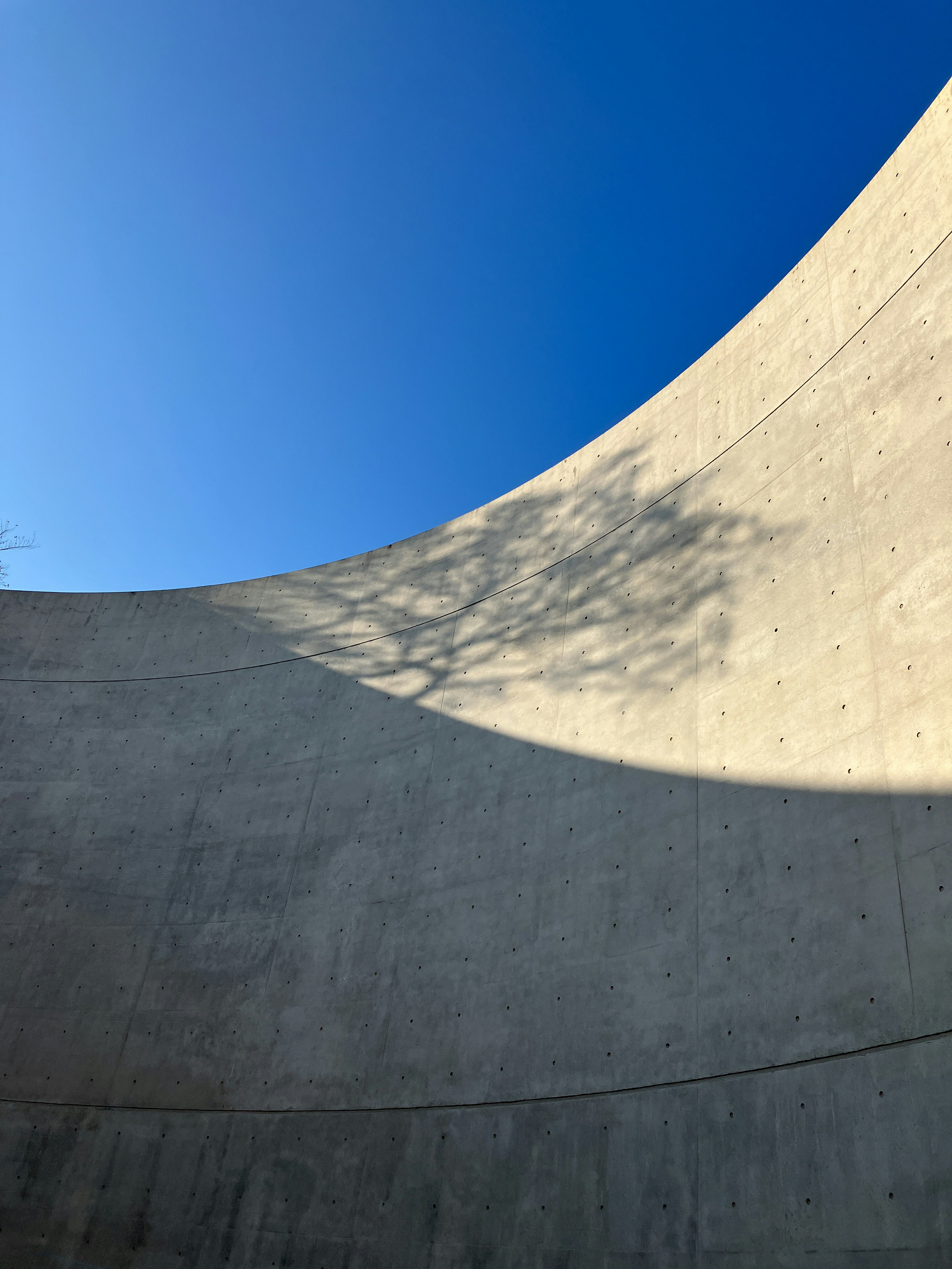 Arc of Light: Shadows Across a Circular Concrete Wall