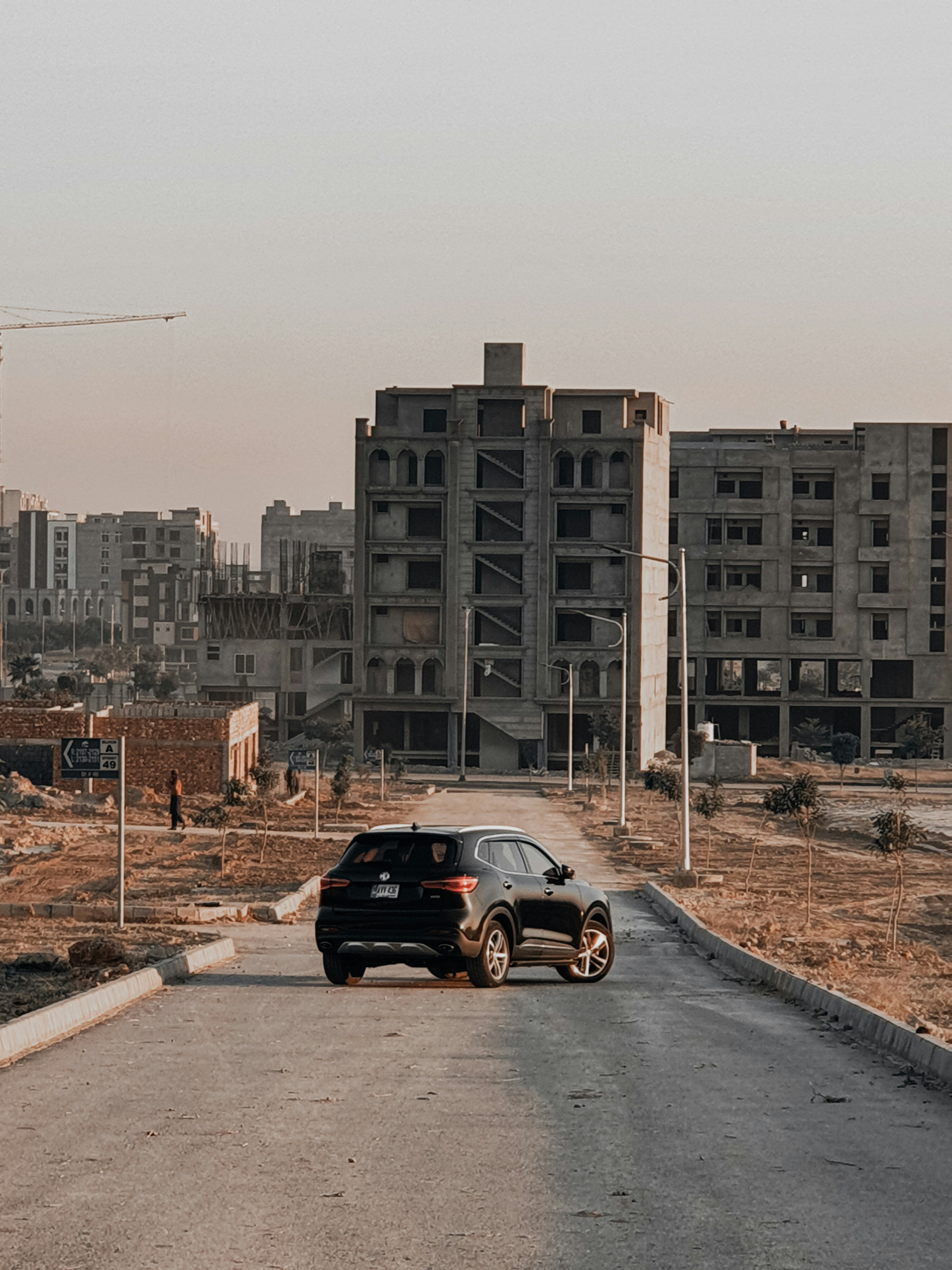 Deserted Boulevard Toward Ghost Towers: A Sedan’s Quiet Ascent