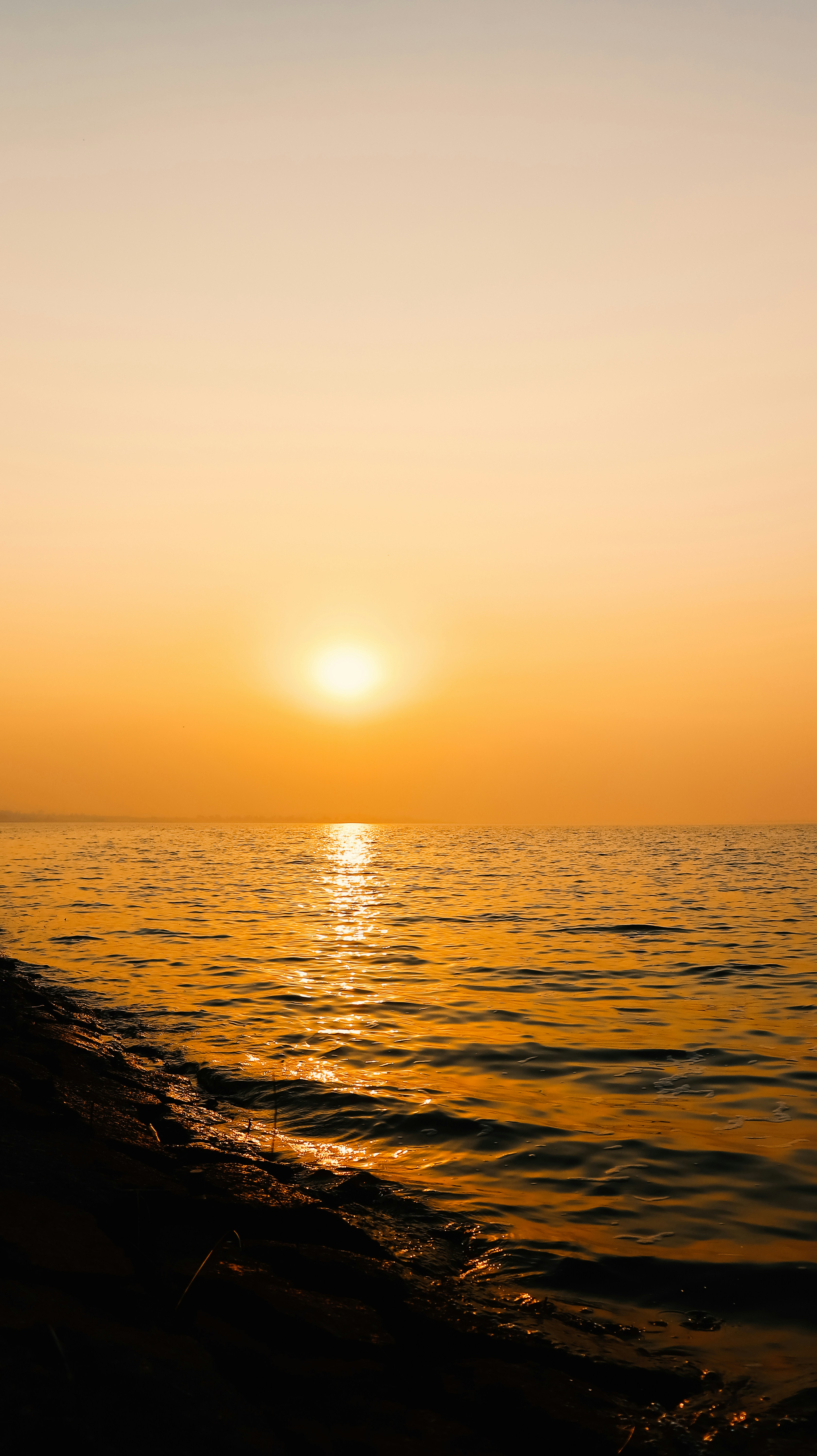 Golden Horizon: Sunset Embrace Over Tranquil Waters