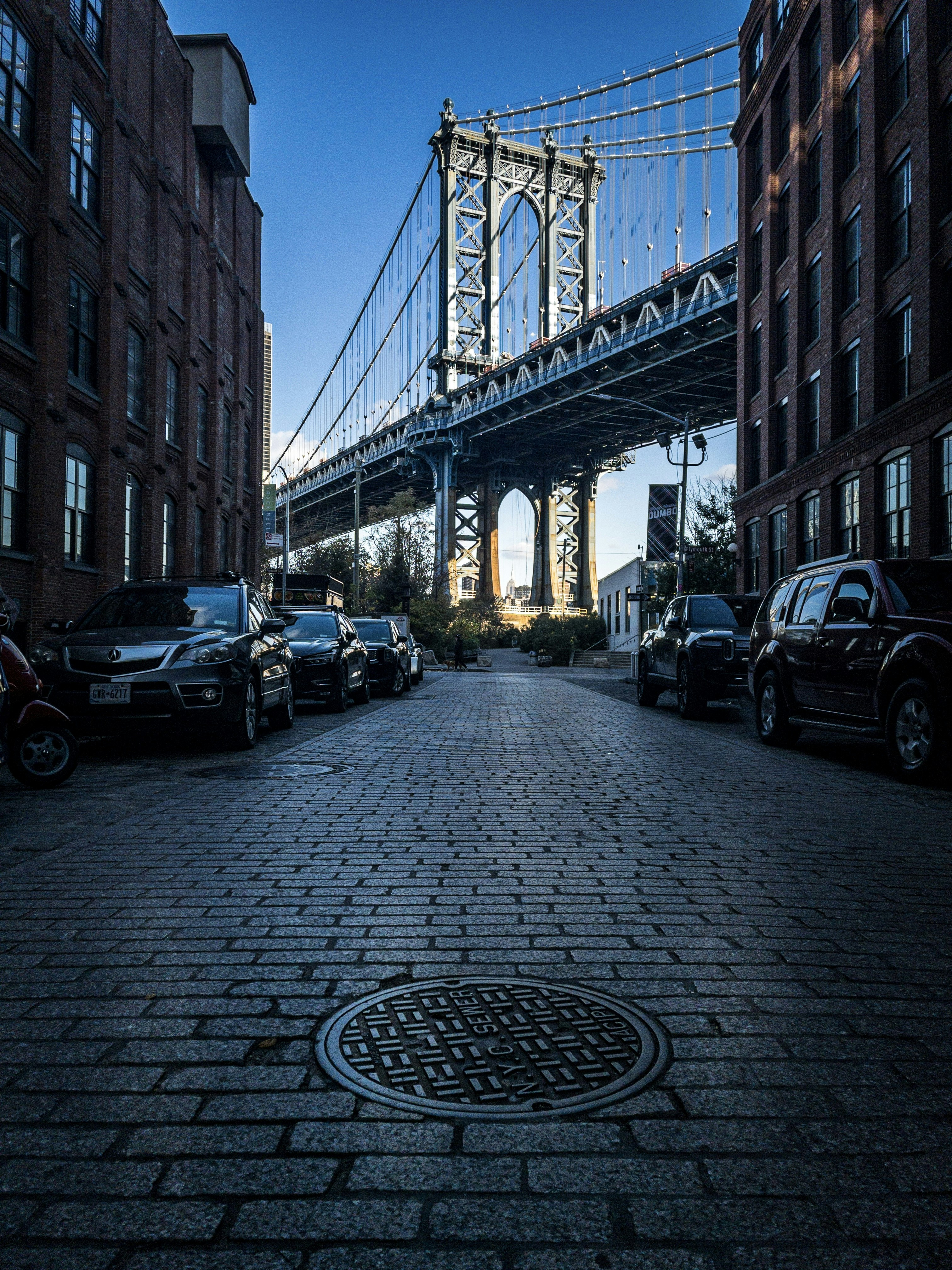 A city street with a bridge in the background photo – Free Urban Image ...