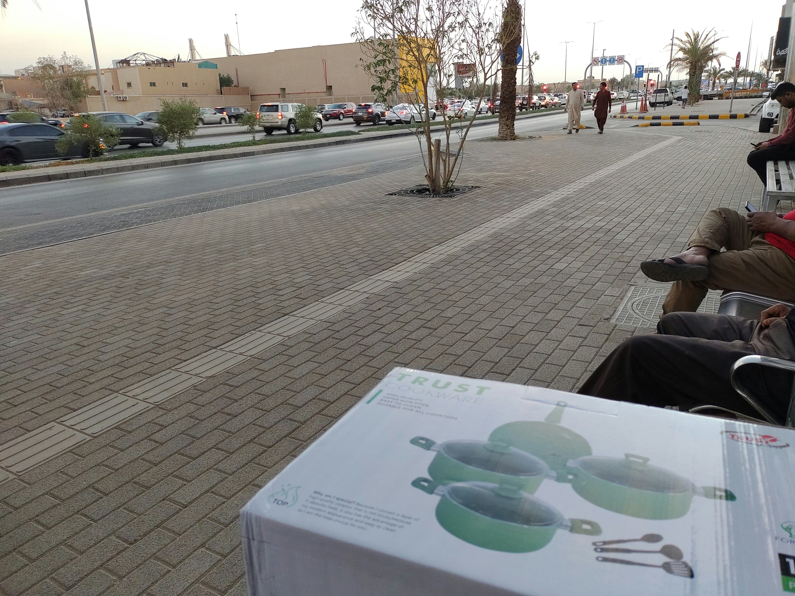 a man sitting on a bench next to a box of food