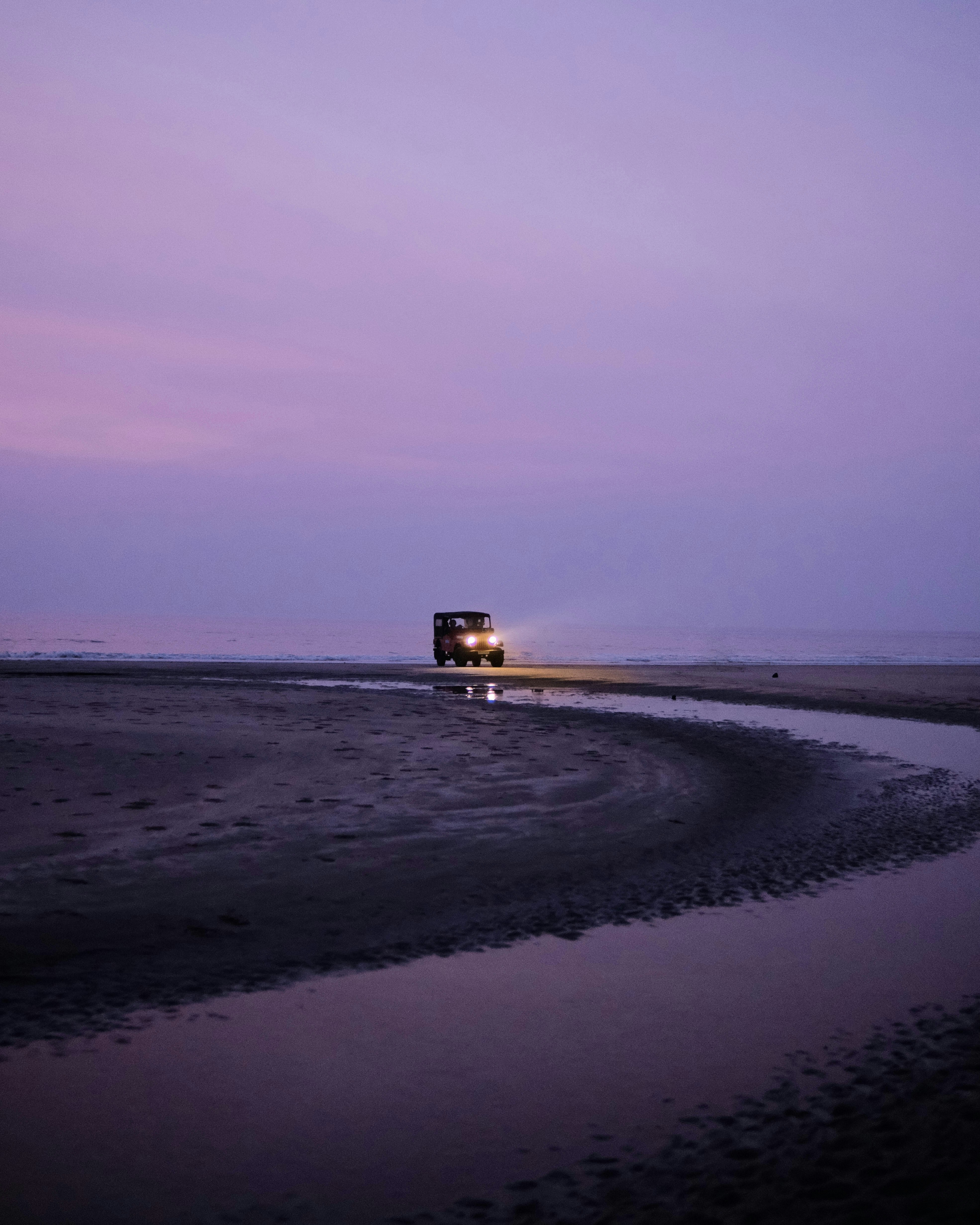a truck driving down a road next to a body of water