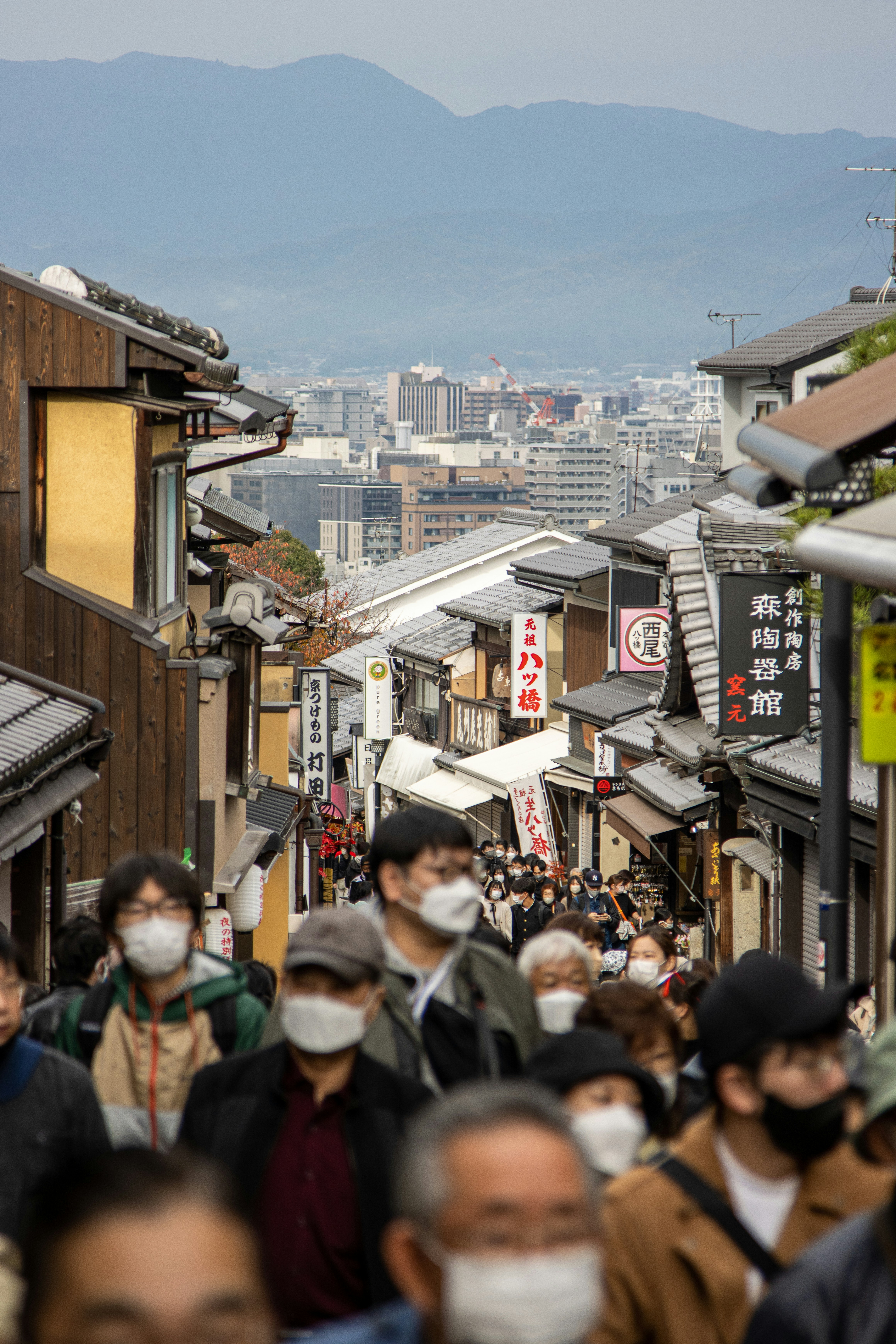 a group of people walking down a street wearing face masks