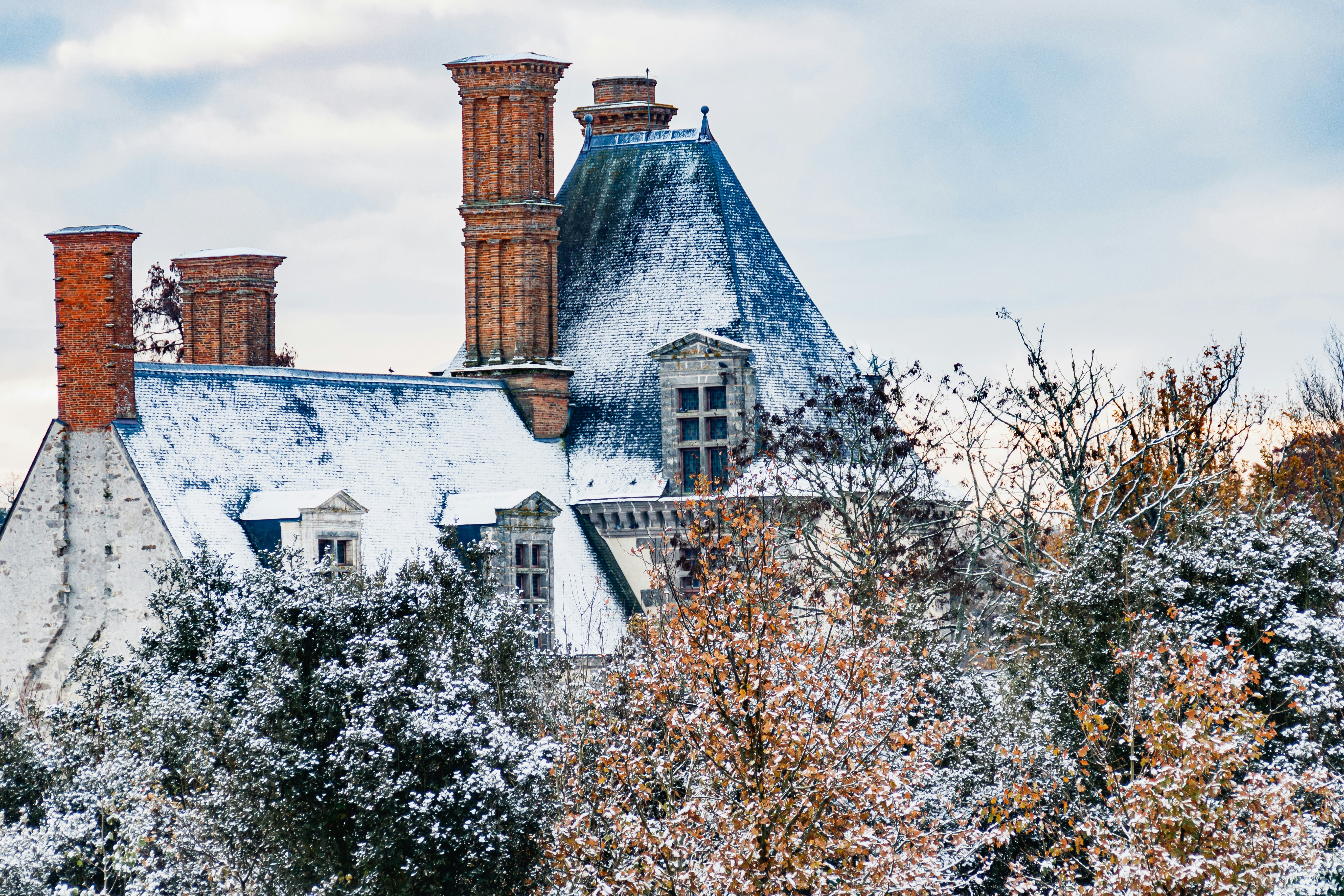 a building with chimneys and a snow covered roof