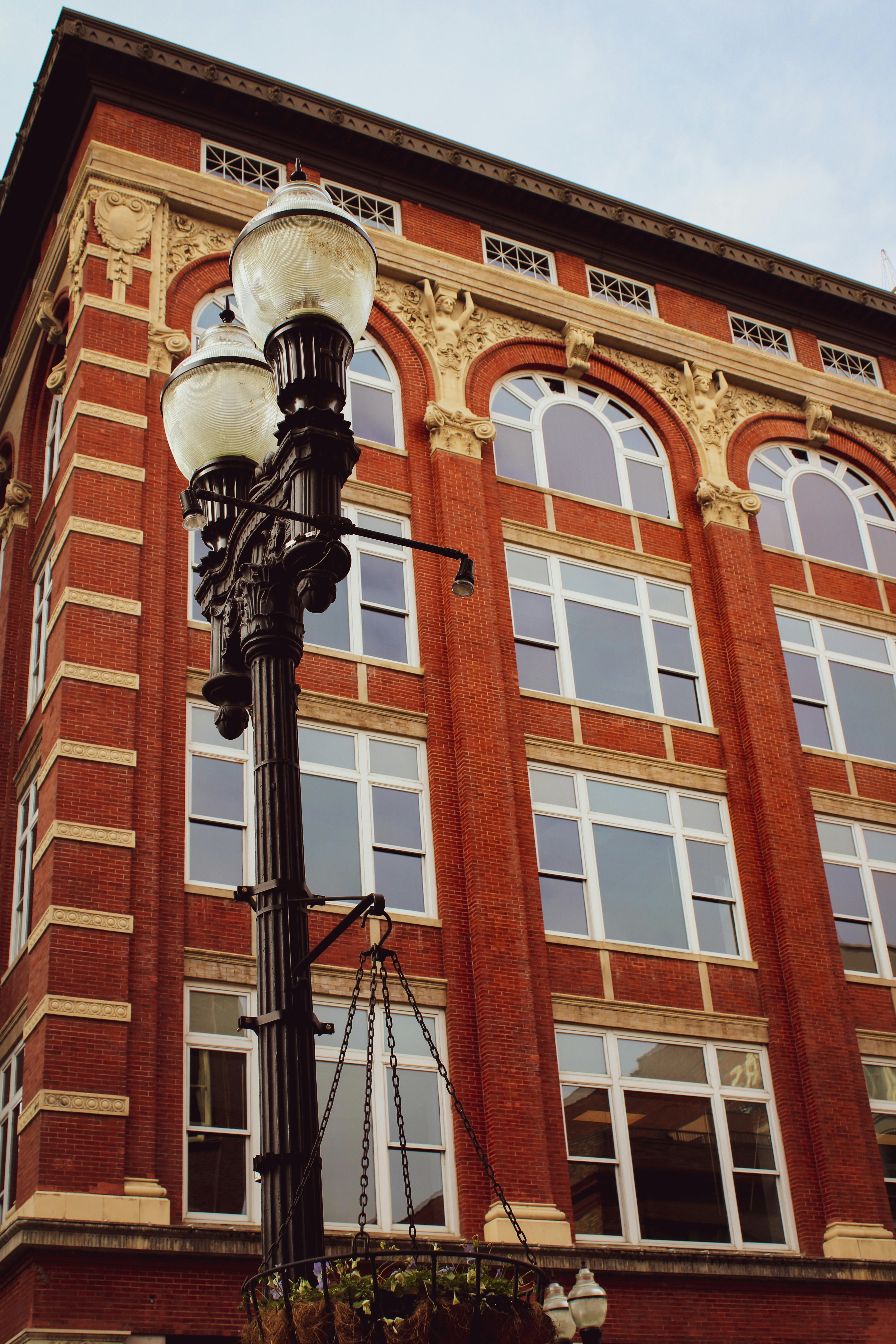 Brick Facade Ledger: A Classical Streetlamp against a Historic Building
