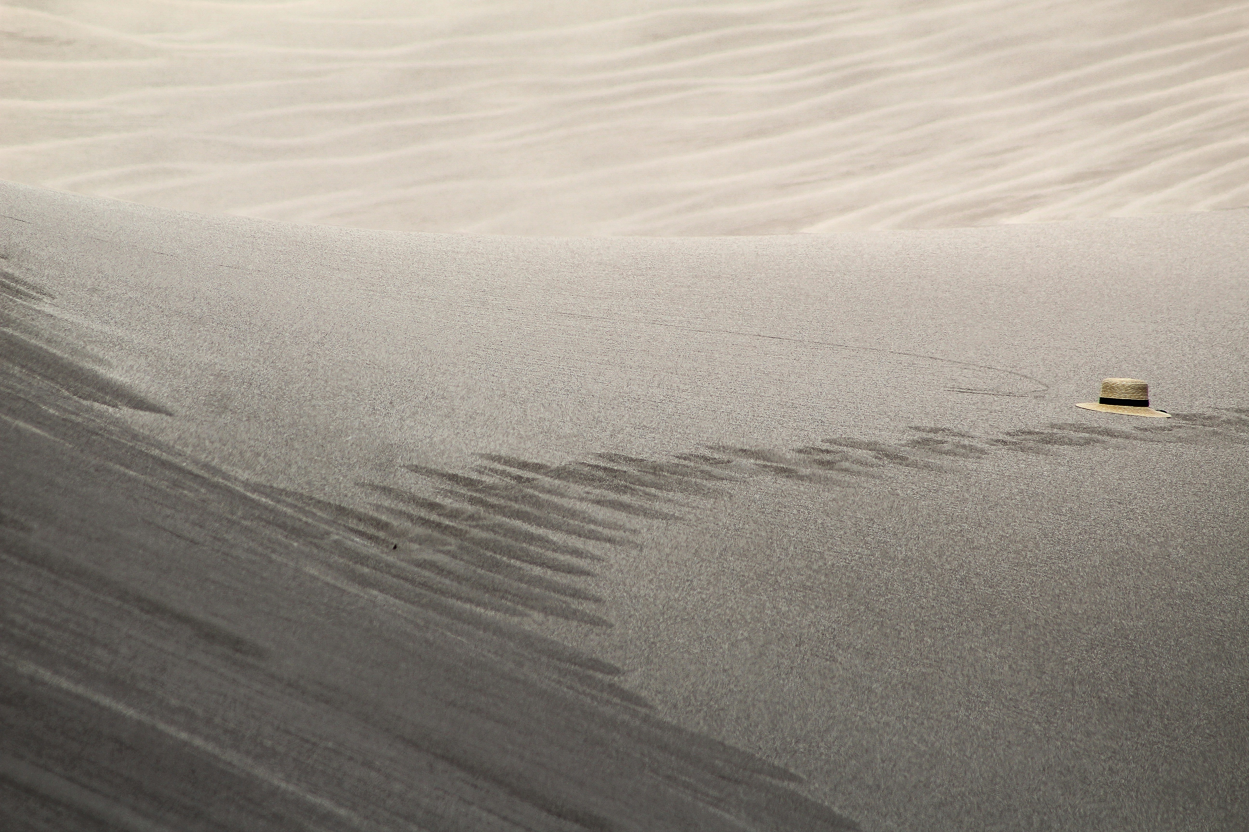 A small white object sitting on top of a sandy beach photo – Free ...