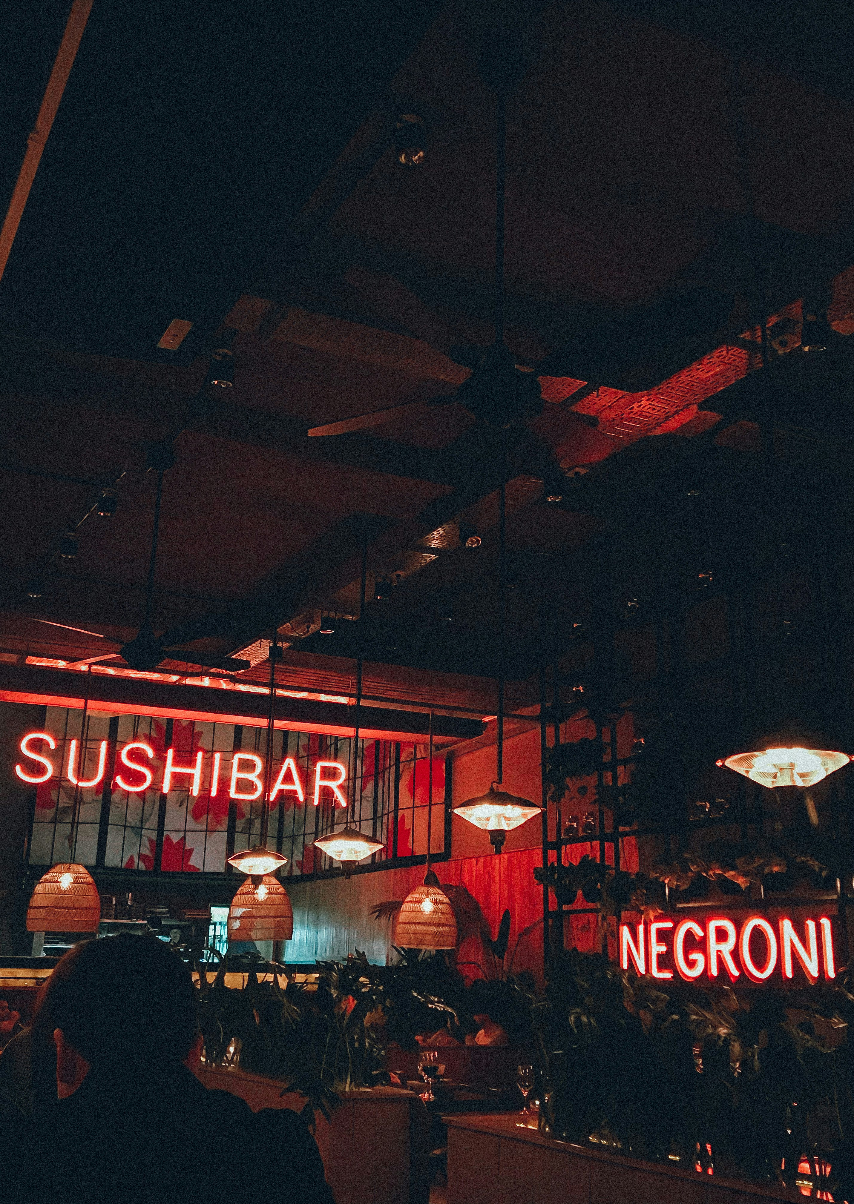 Crimson Neon and Lantern Glow Inside a Nighttime Sushi Bar