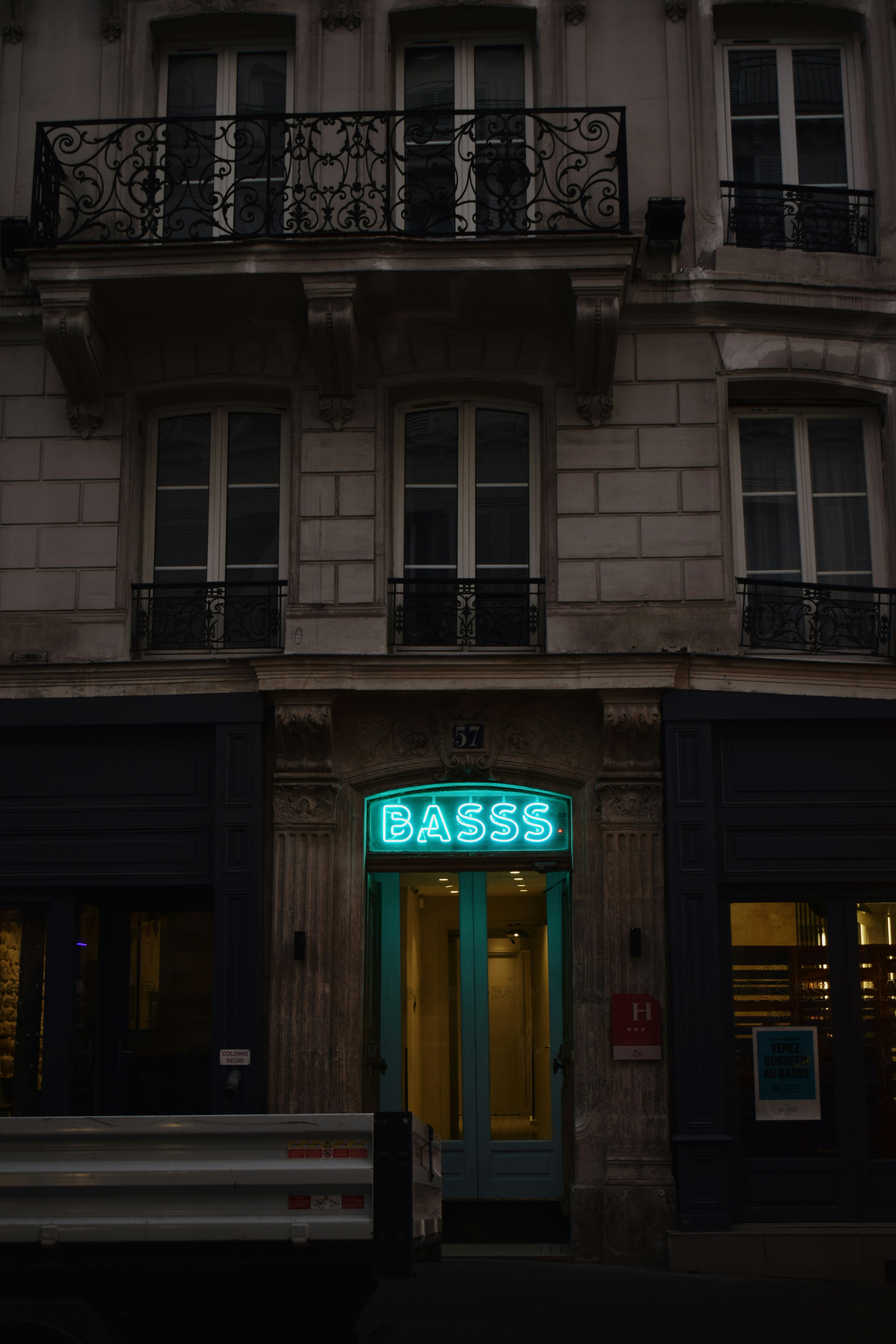 Neon Sign above a Blue Door Illuminates a Narrow Parisian Street