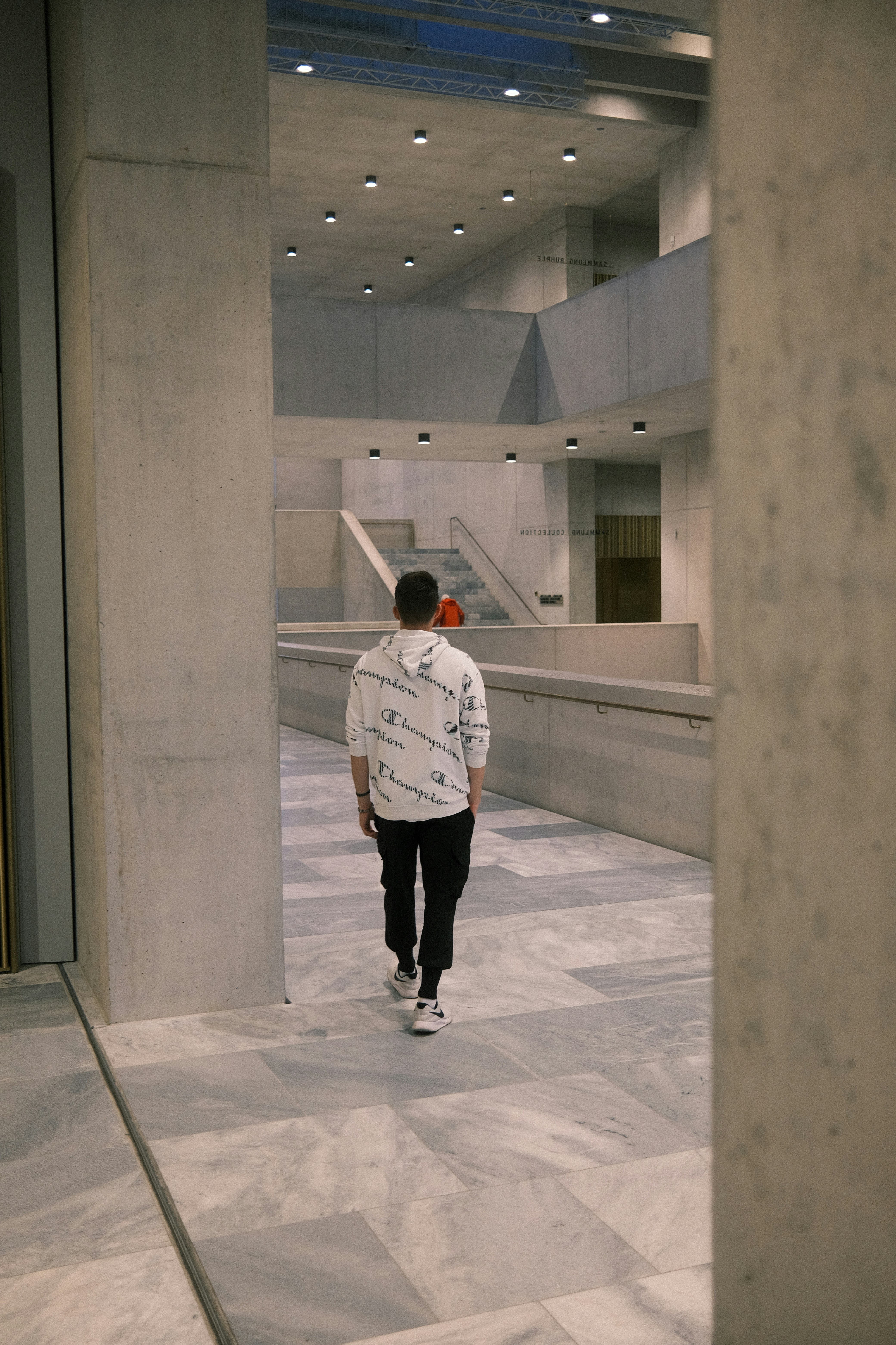 A man walking down a hallway in a building photo – Free Zürich Image on ...
