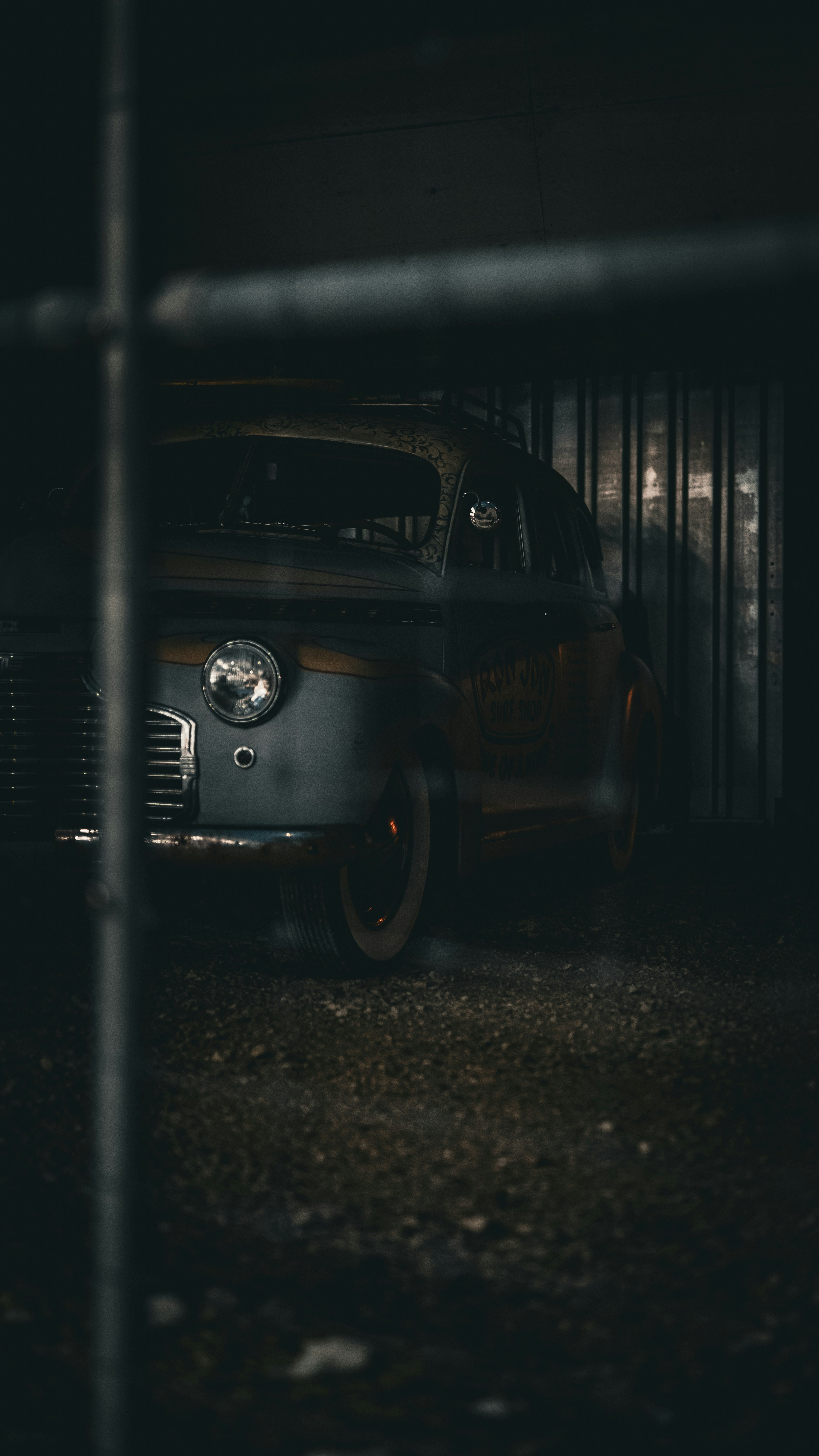 an old car is parked in a dark garage