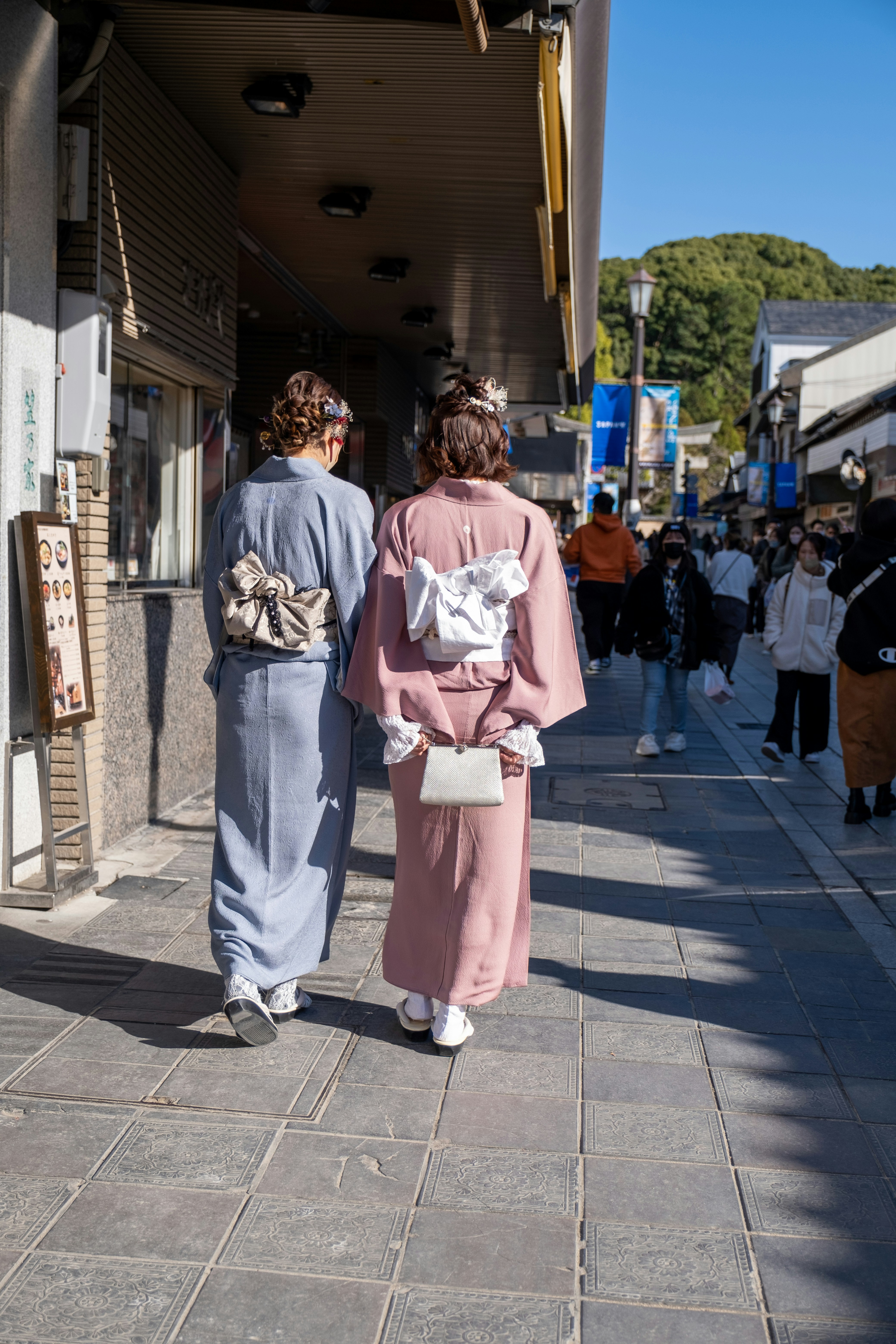 Pastel-kimono stroll through a sunlit arcade