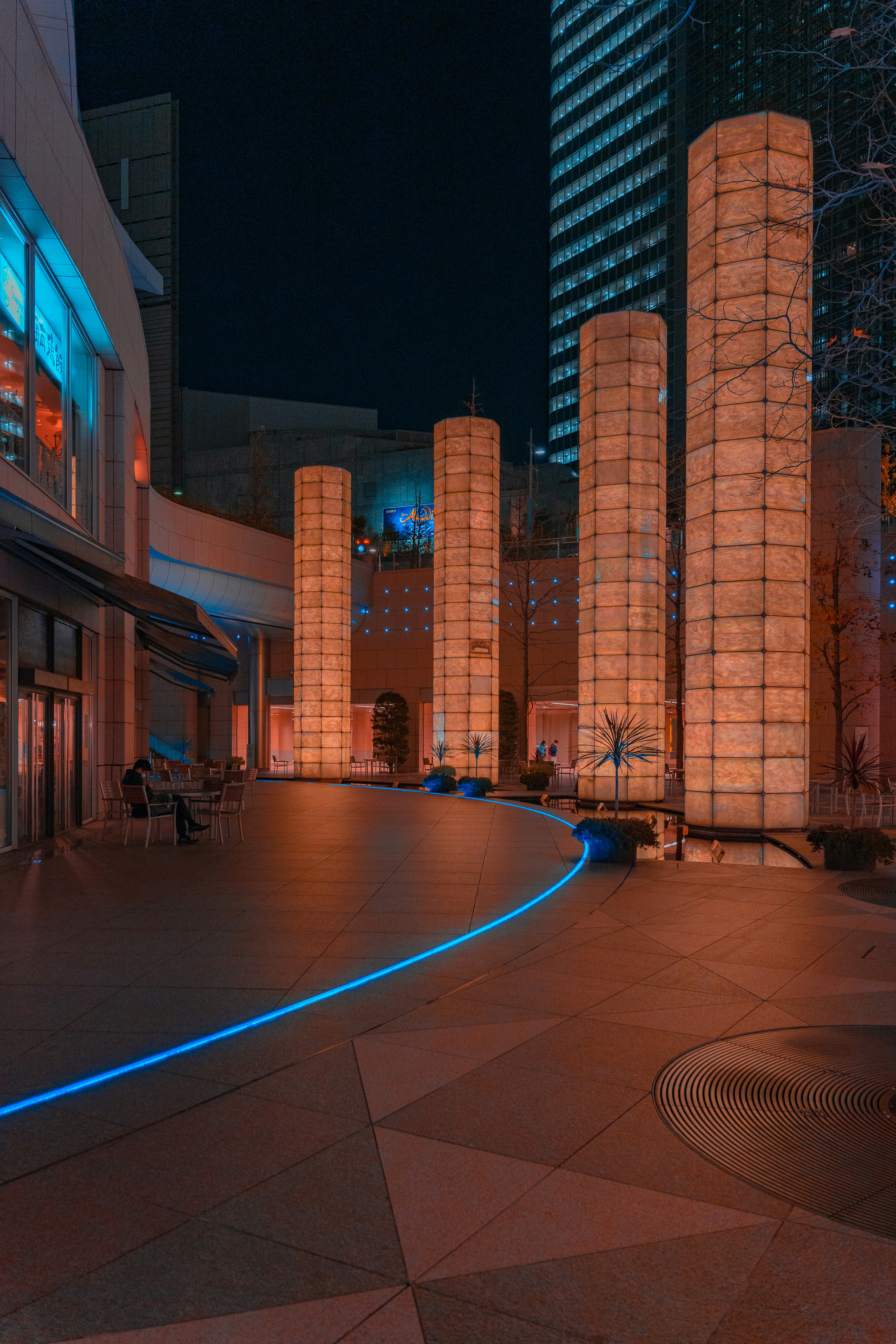 A city square with a clock tower lit up at night photo – Free Floor ...