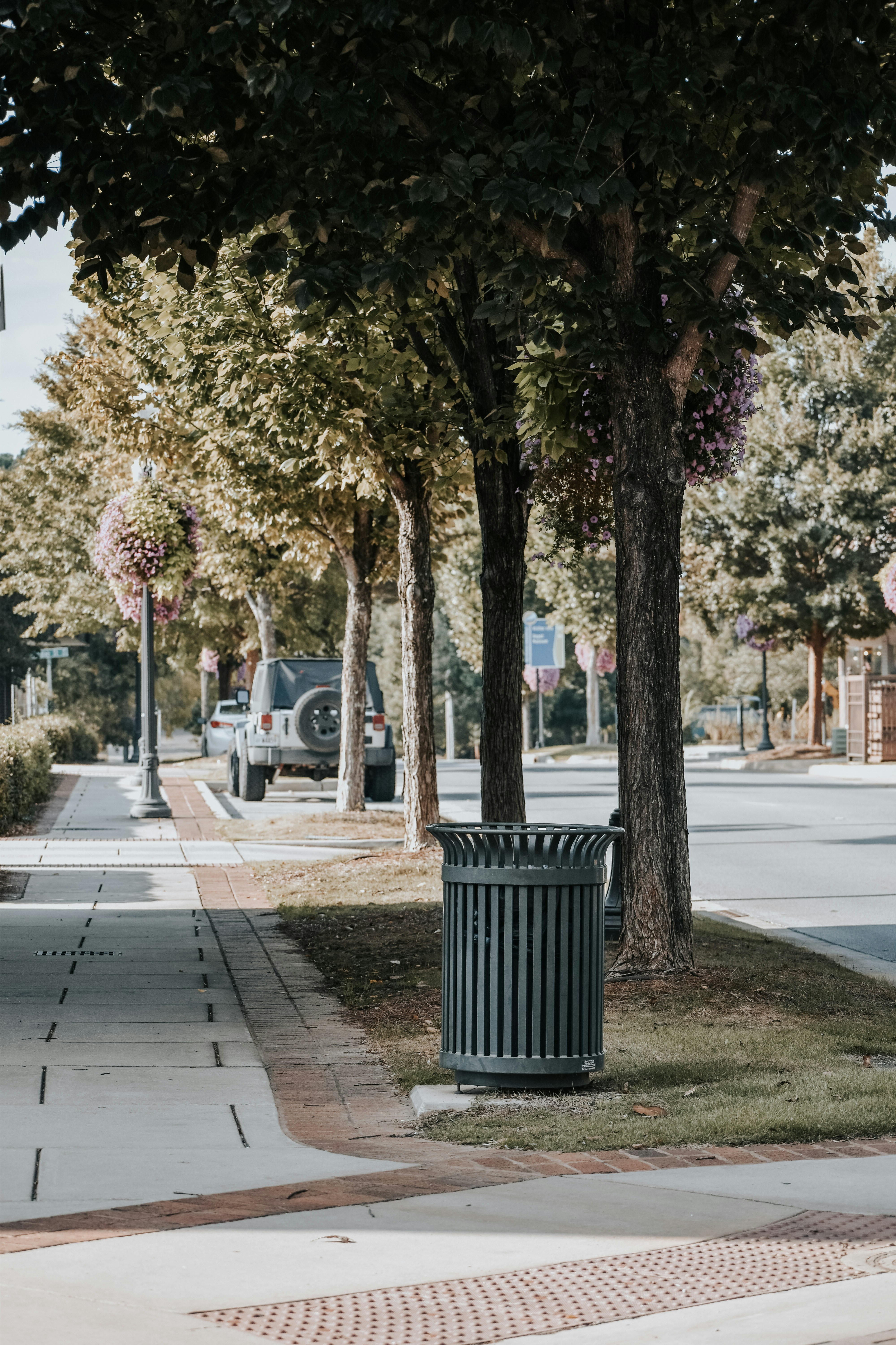 Foto Tempat sampah yang duduk di sisi trotoar – Gambar Pusat kota ...