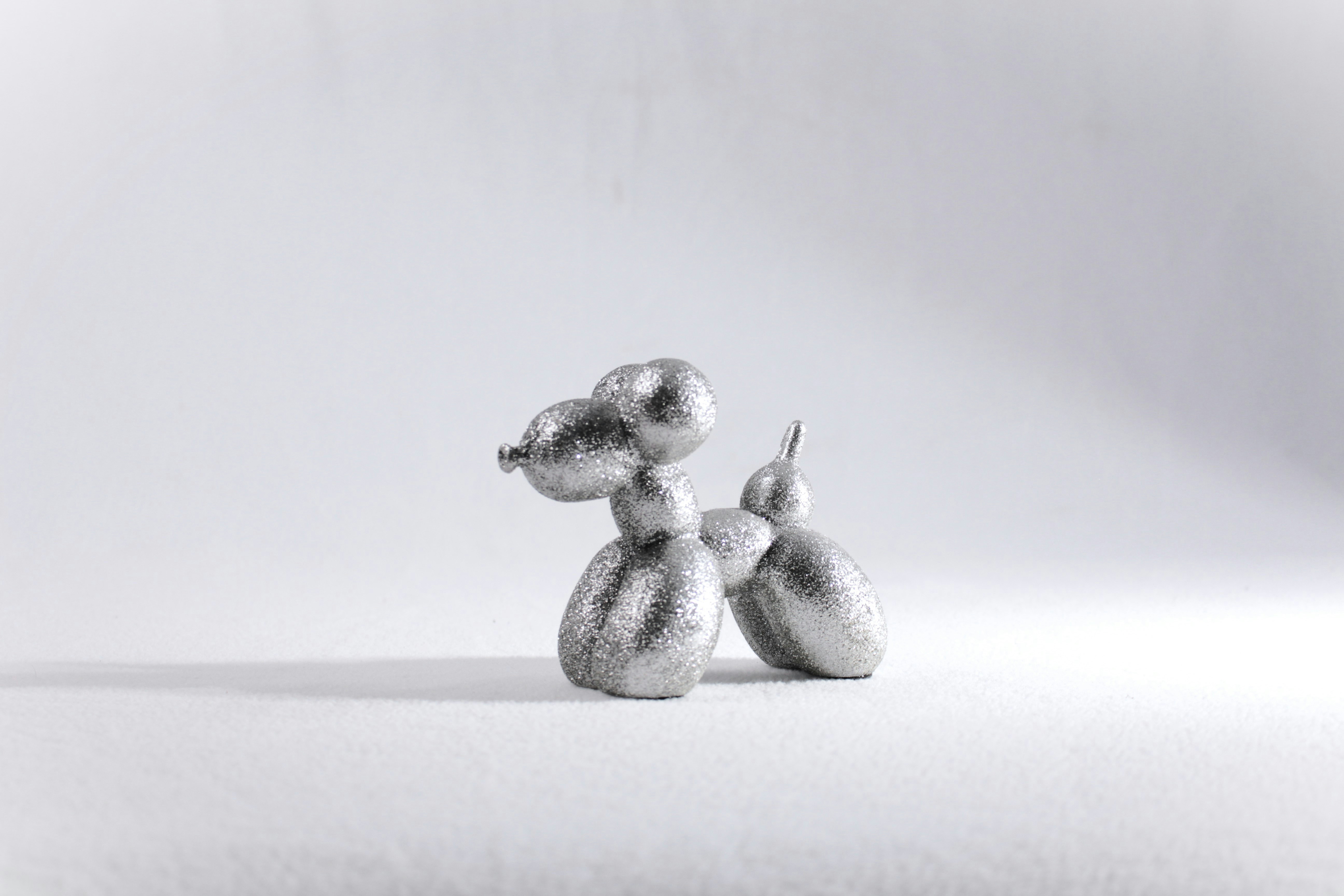 Foto Una estatua de perro plateado sentada encima de una superficie ...