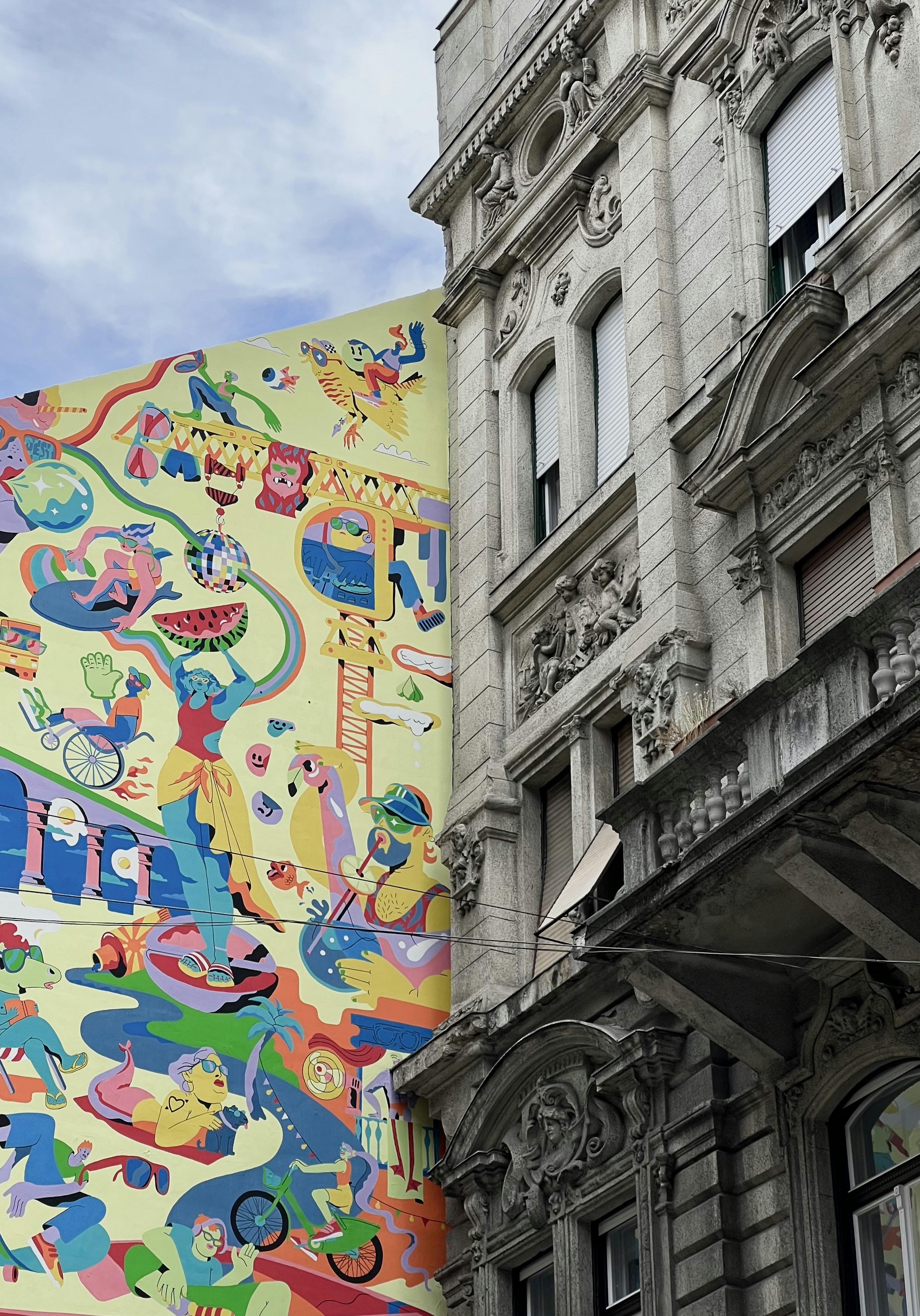 Vibrant mural beside a stone façade: colors spilling from the left into architectural detail