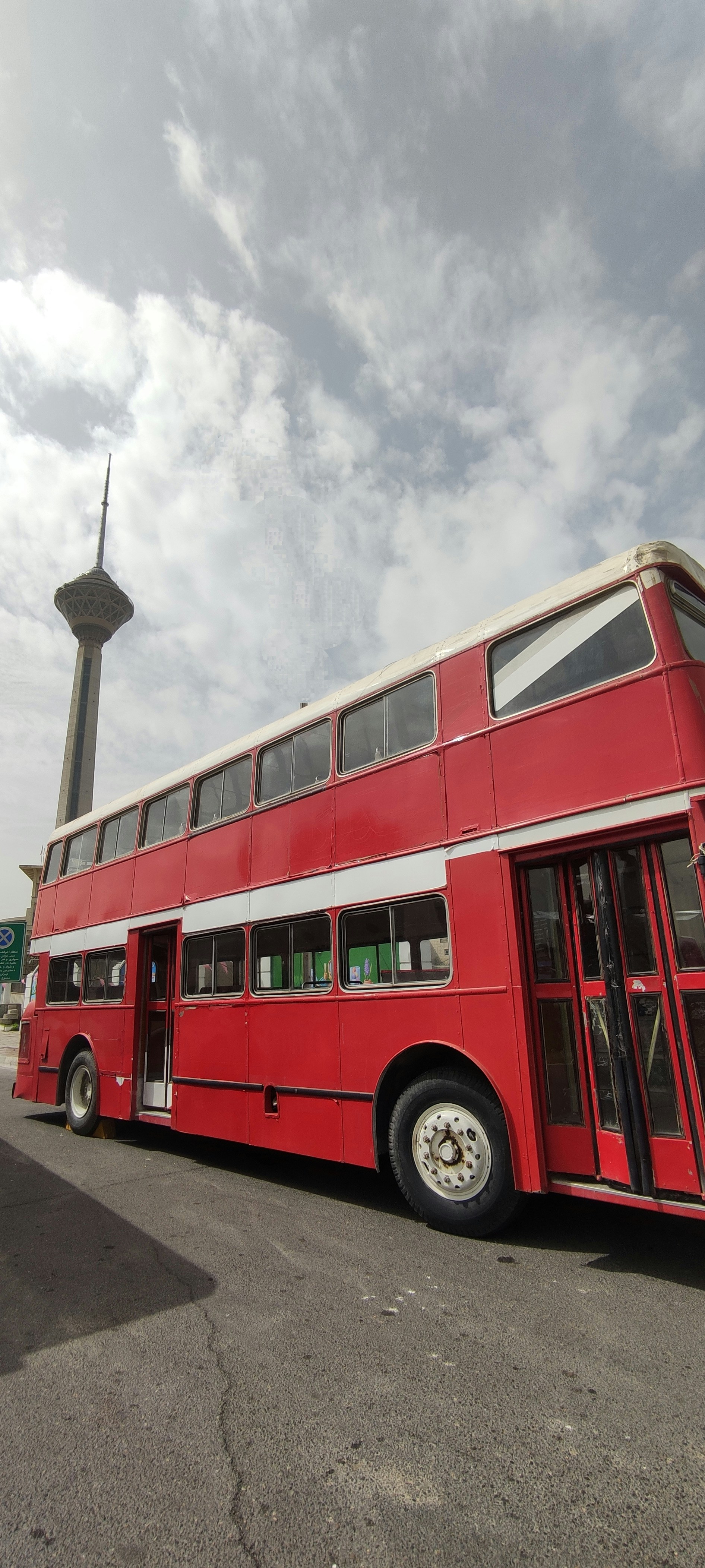 A red double decker bus parked in a parking lot photo – Free Tehran ...