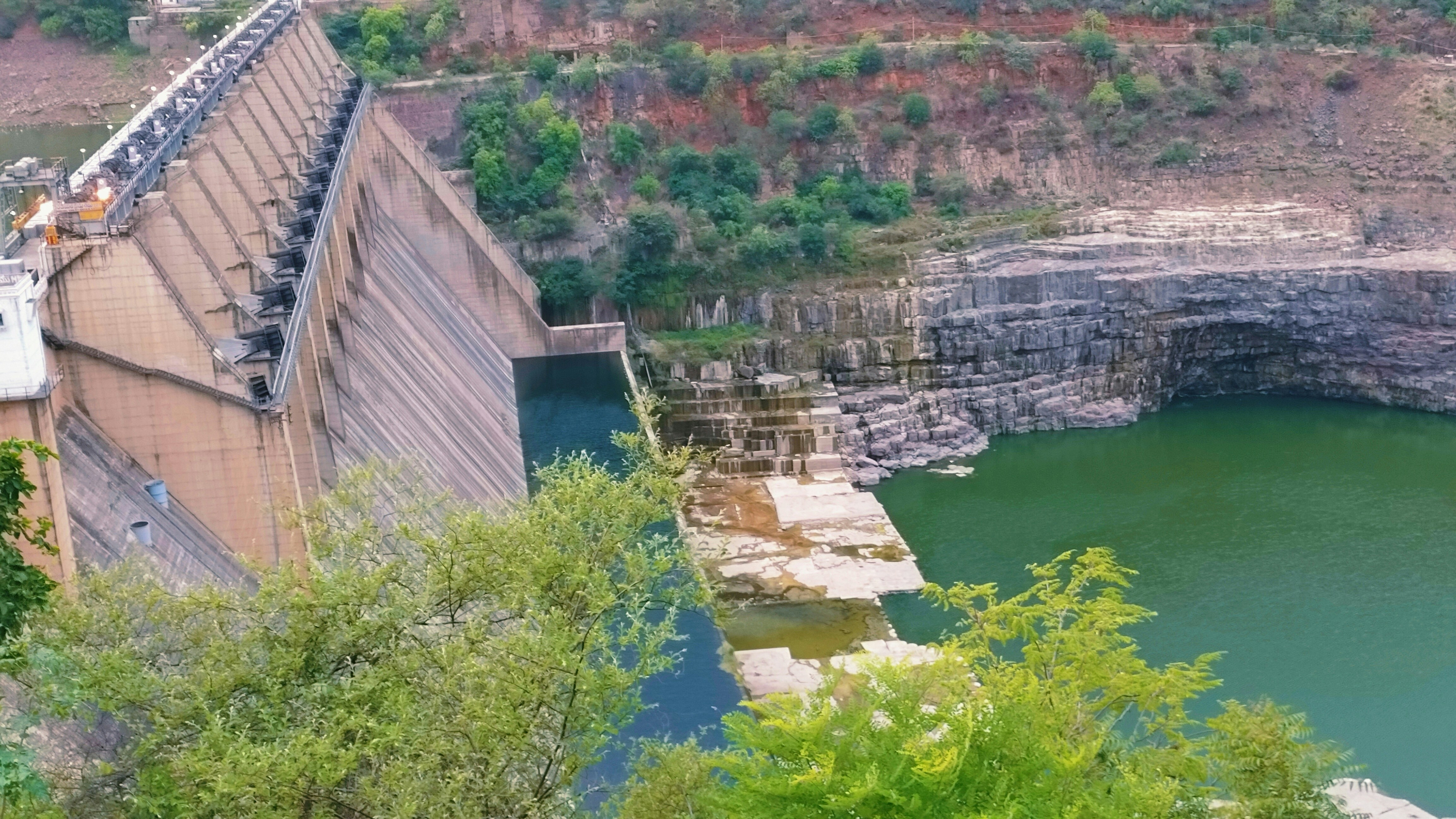 A view of a dam with water coming out of it photo – Free Water Image on ...