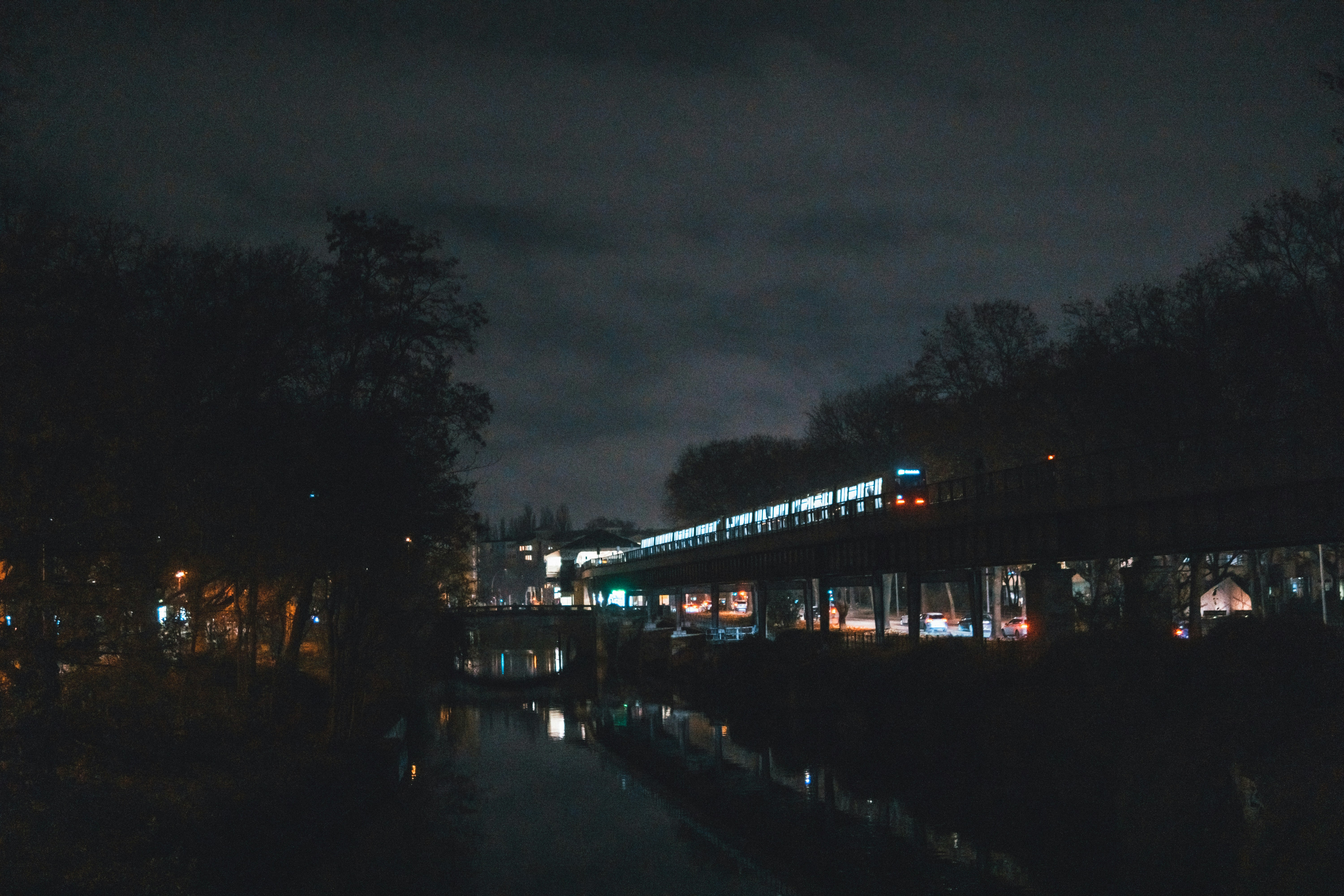 Night Rail Over the River: Quiet Lights Beneath a Gloomy Sky