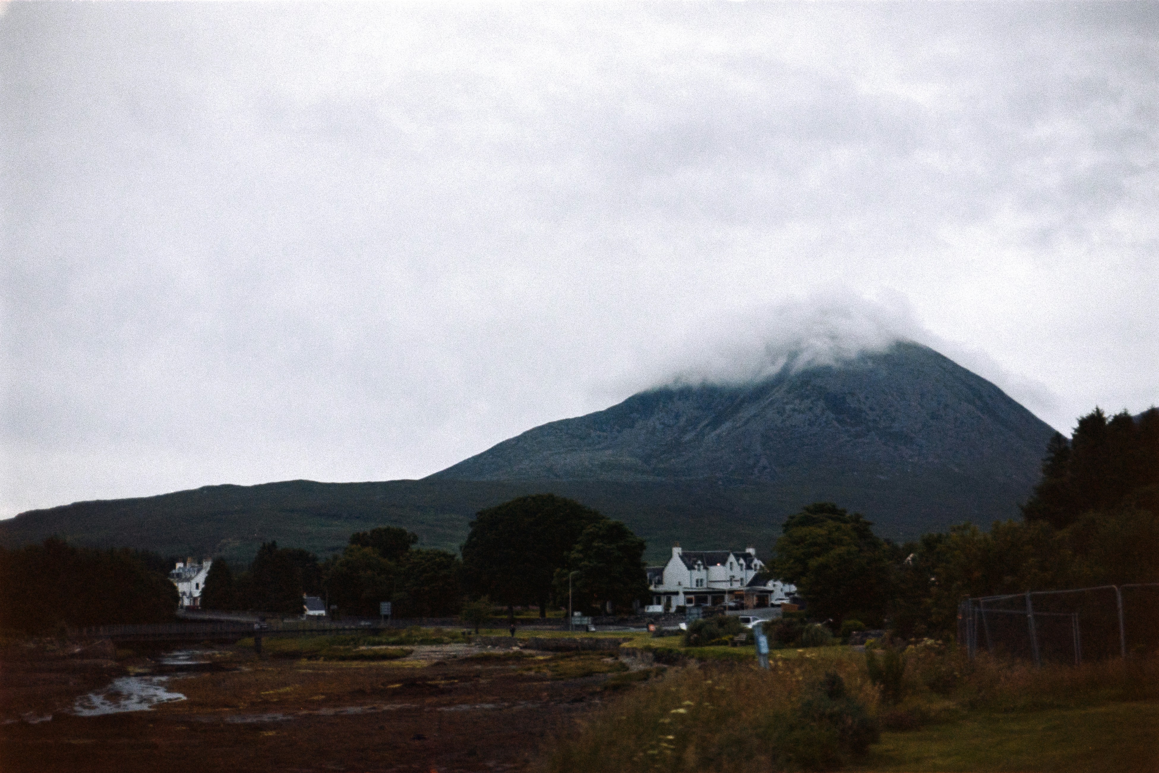 A large mountain in the distance with houses in the foreground photo ...