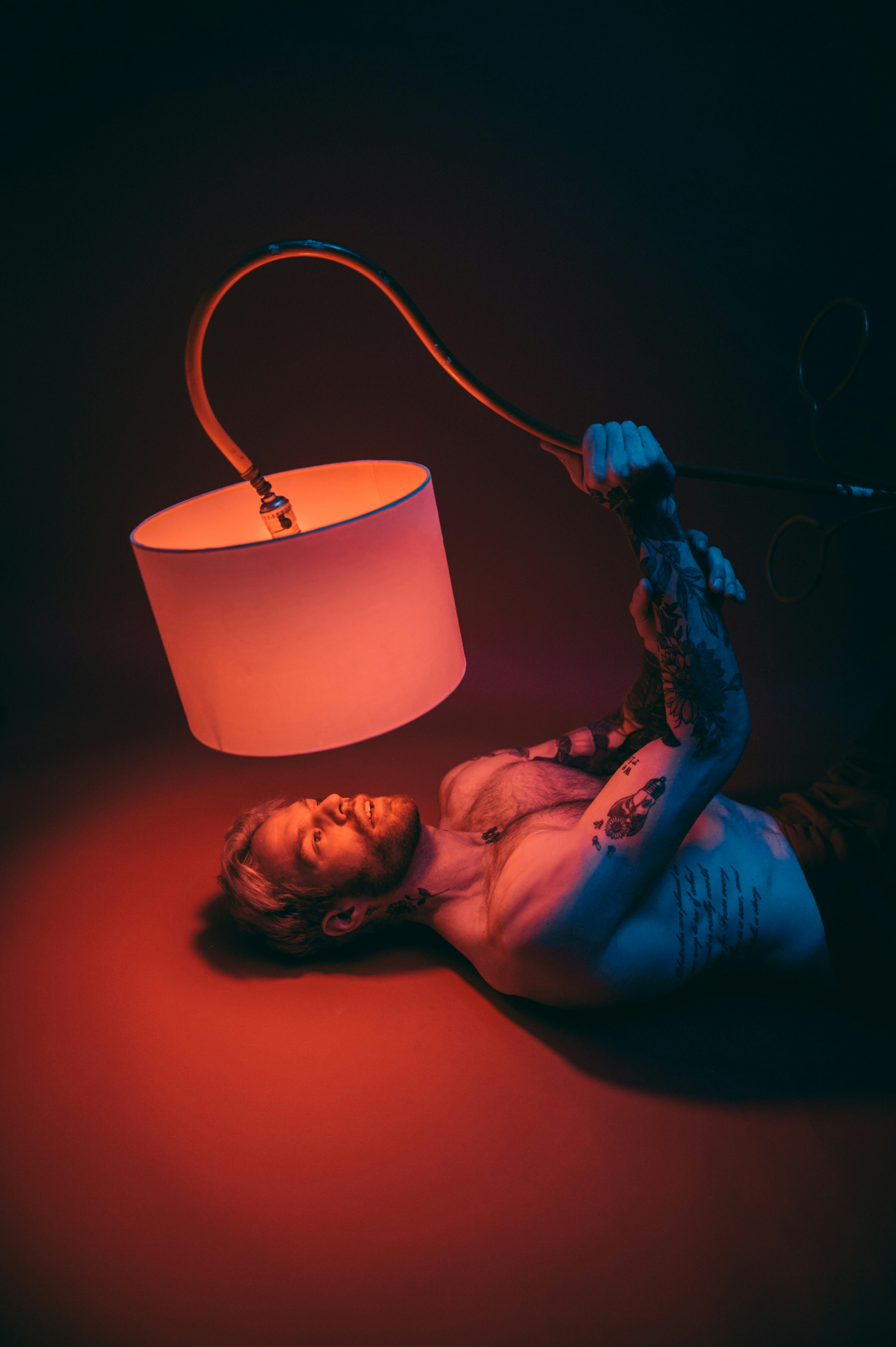 A woman laying on the ground next to a lamp photo – Free Lighting Image ...