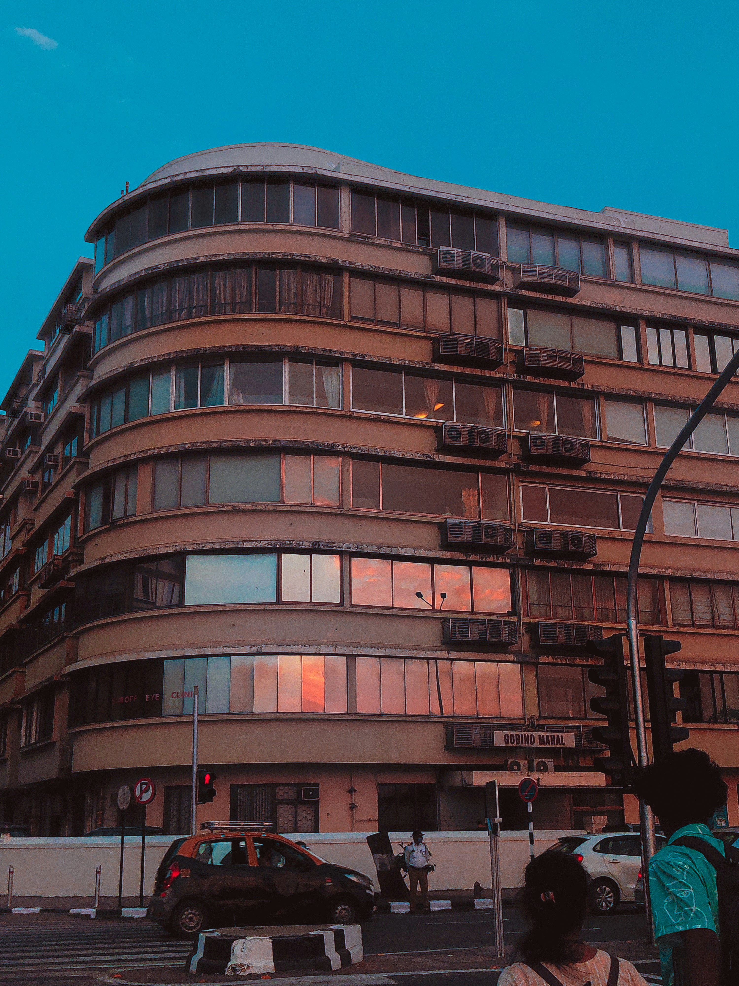Rounded Corner Facade: Blue Sky Glow on a Curved City Block