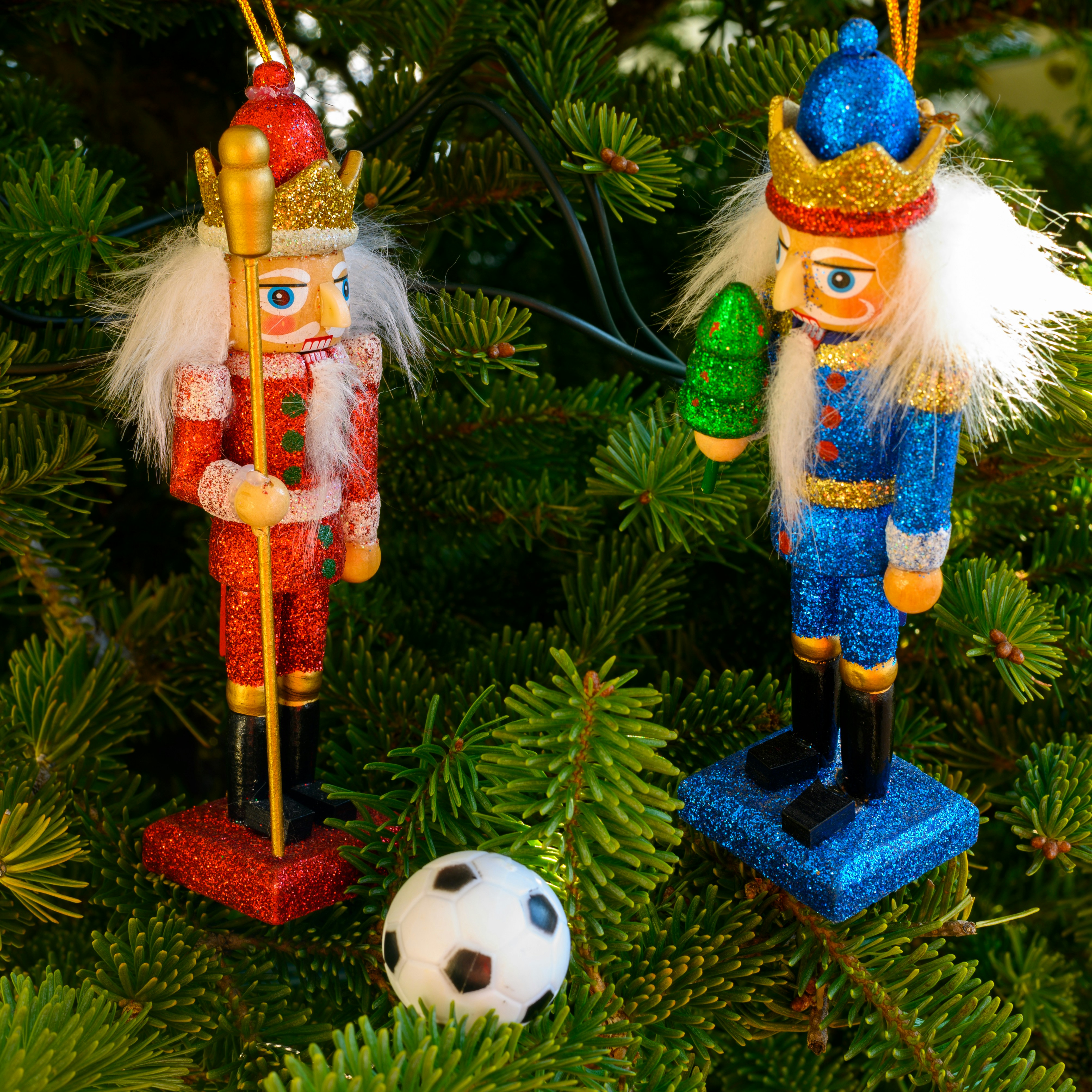 A couple of nutcrackers sitting on top of a christmas tree photo – Free ...