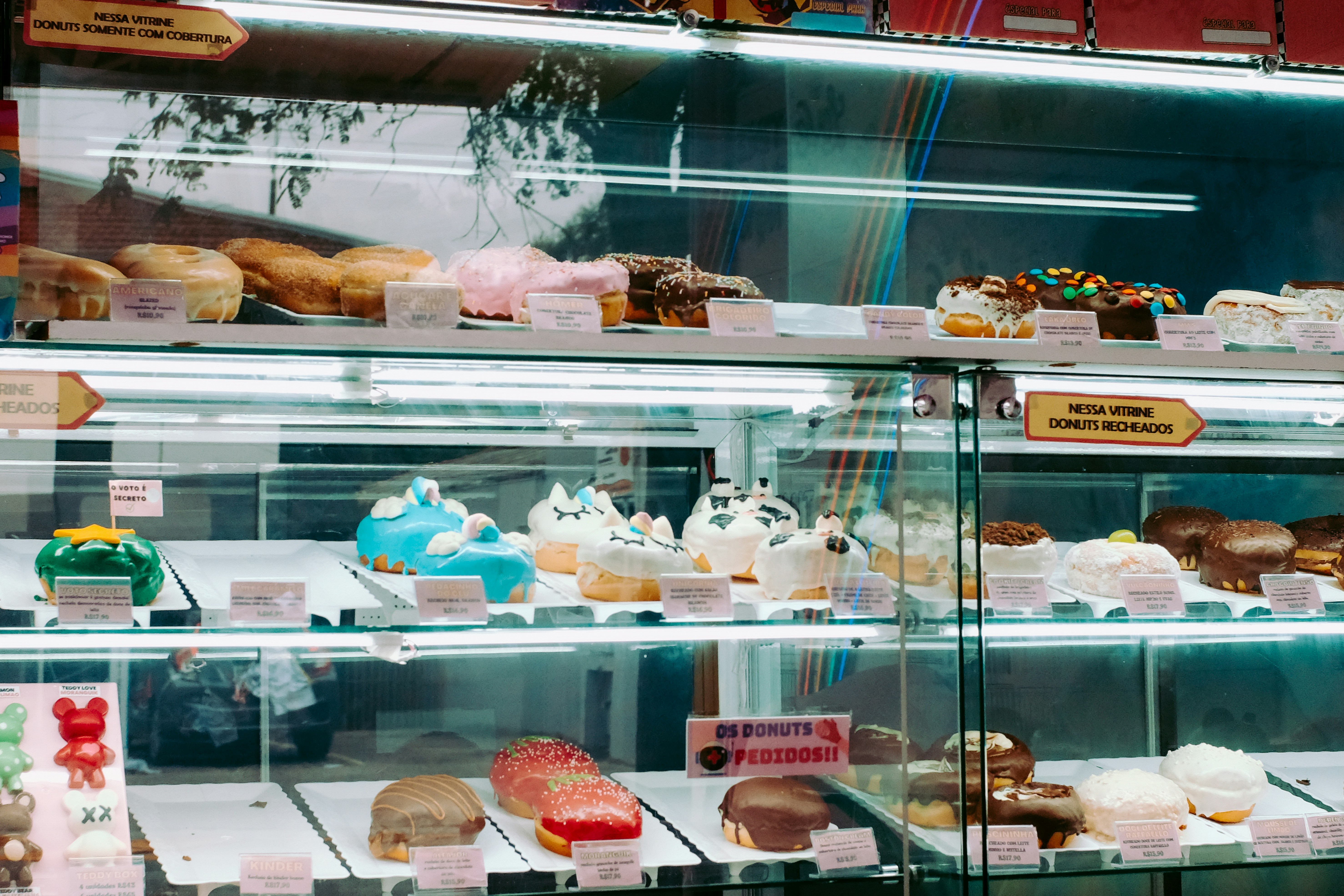 A display case filled with lots of different types of donuts photo ...