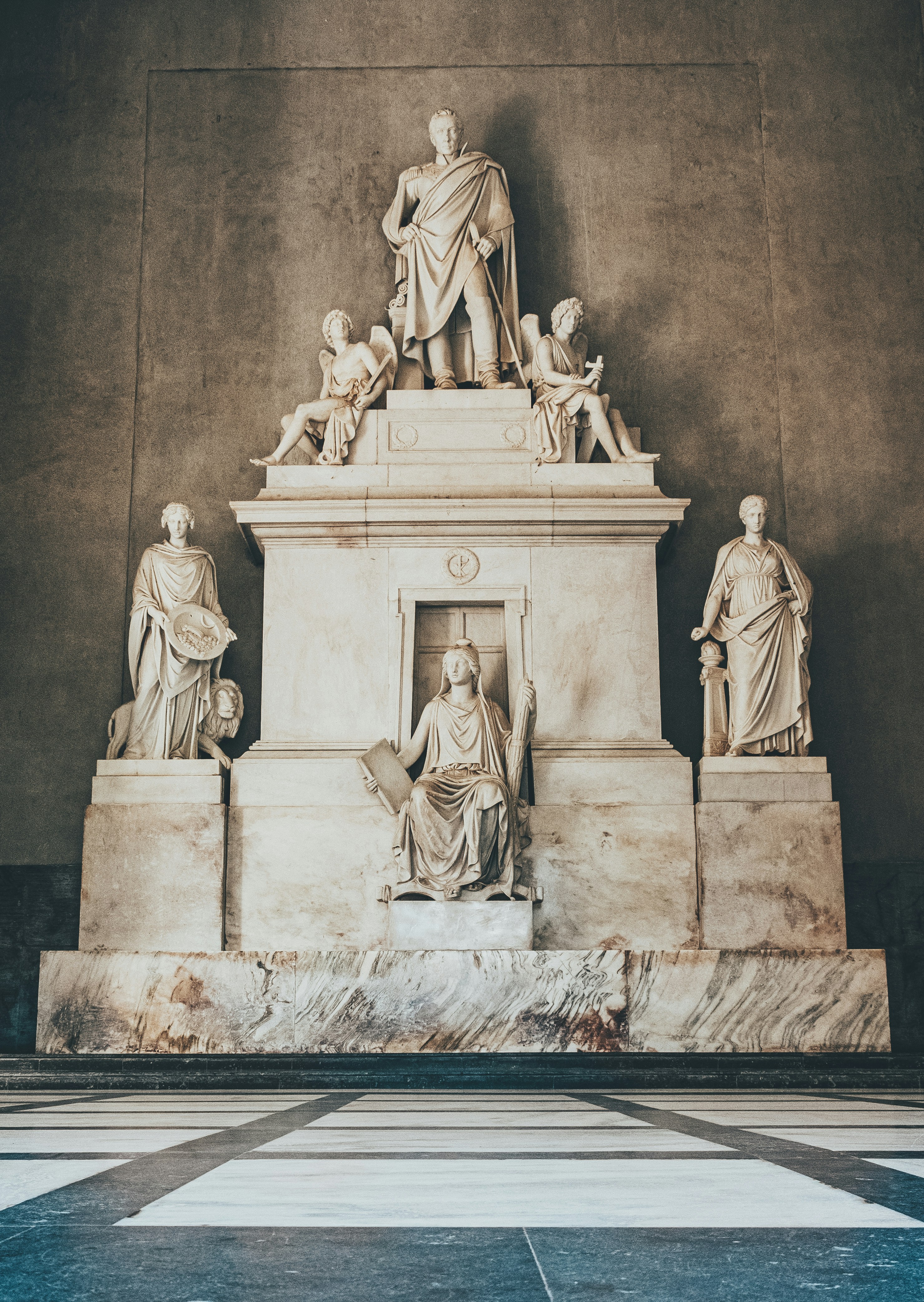 Majestic marble monument featuring a central seated figure surrounded by allegorical representations, showcasing historical significance and artistry.